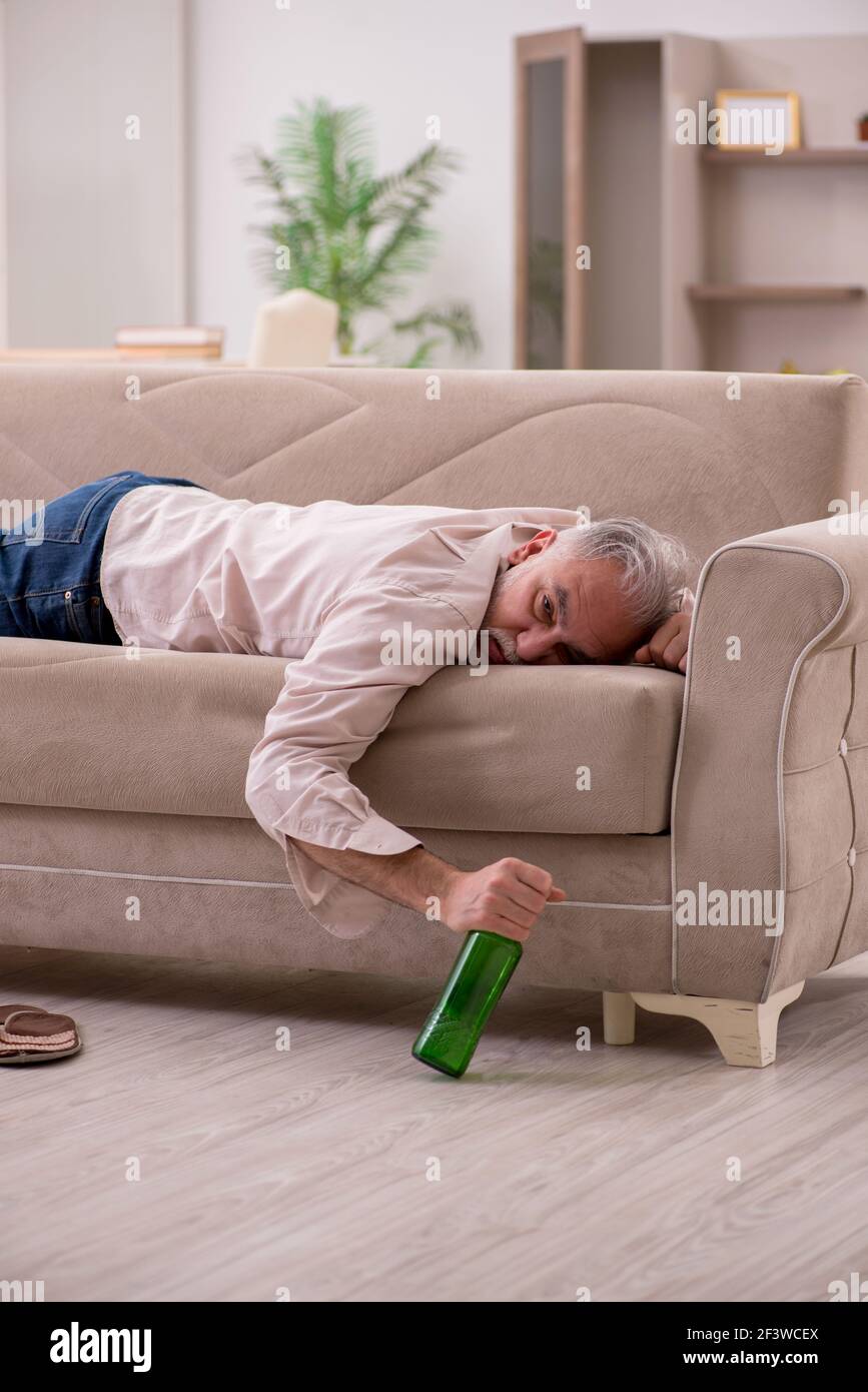 Aged man drinking alcohol at home Stock Photo - Alamy