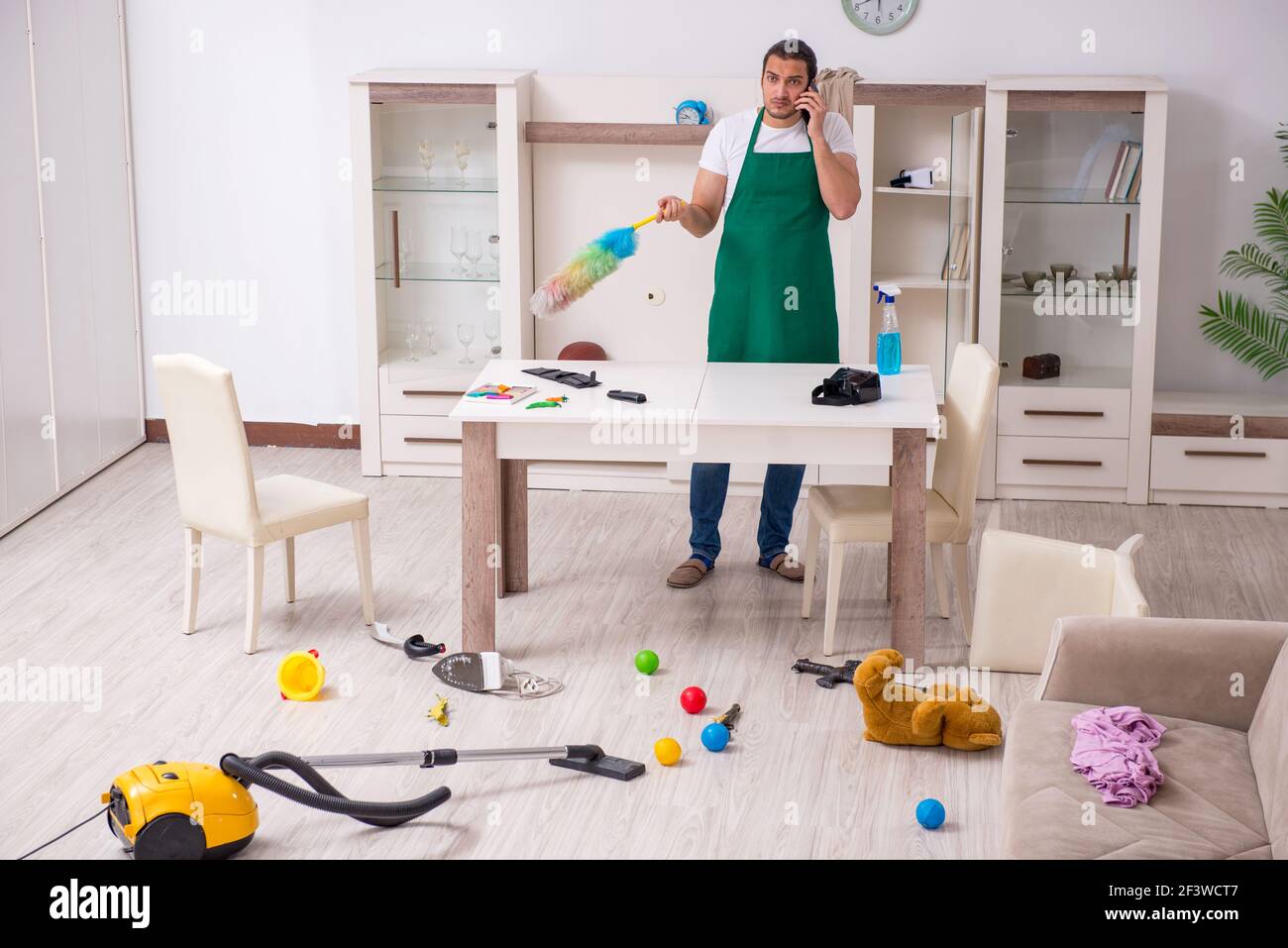 Young contractor cleaning the flat after kids' party Stock Photo - Alamy