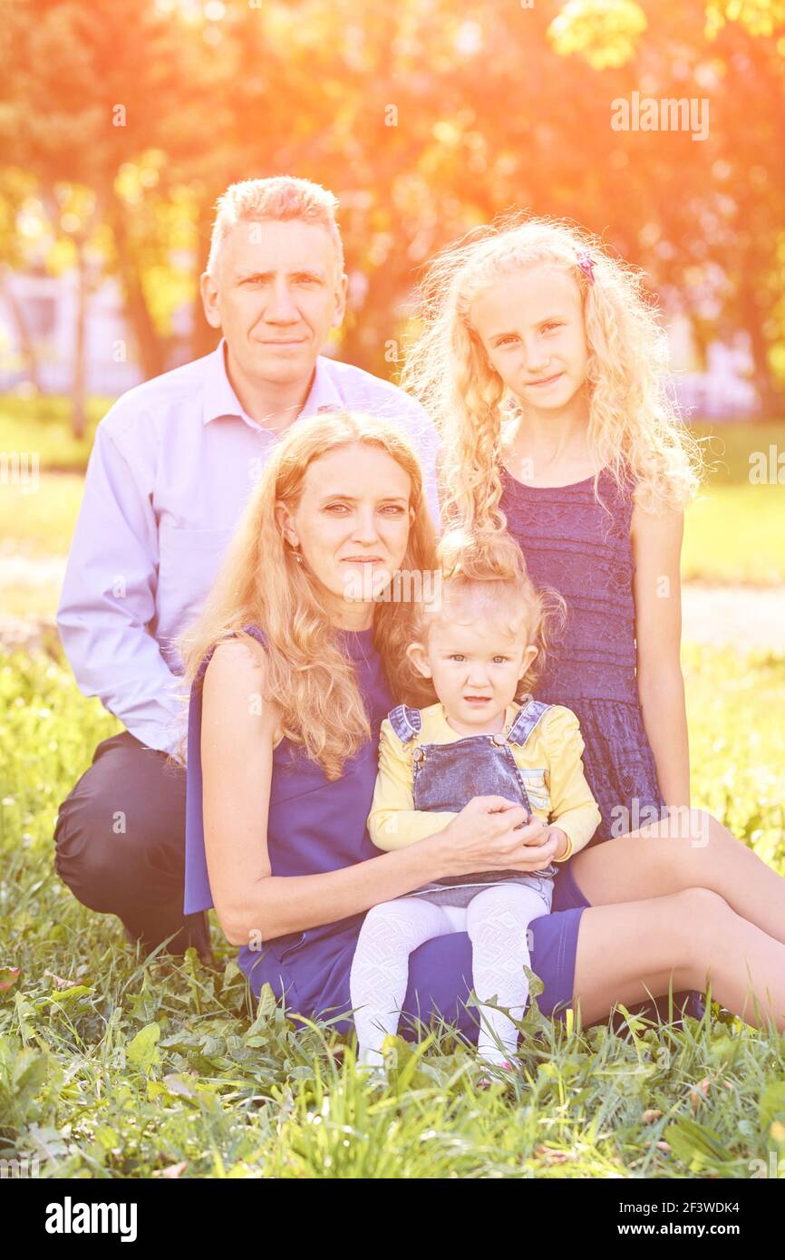Parents with two little daughters at park. Family portrait. Nature ...