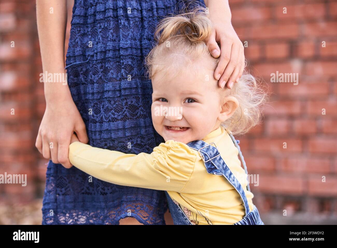 Little girl hug sister leg. Female child portrait. Happy people Stock ...