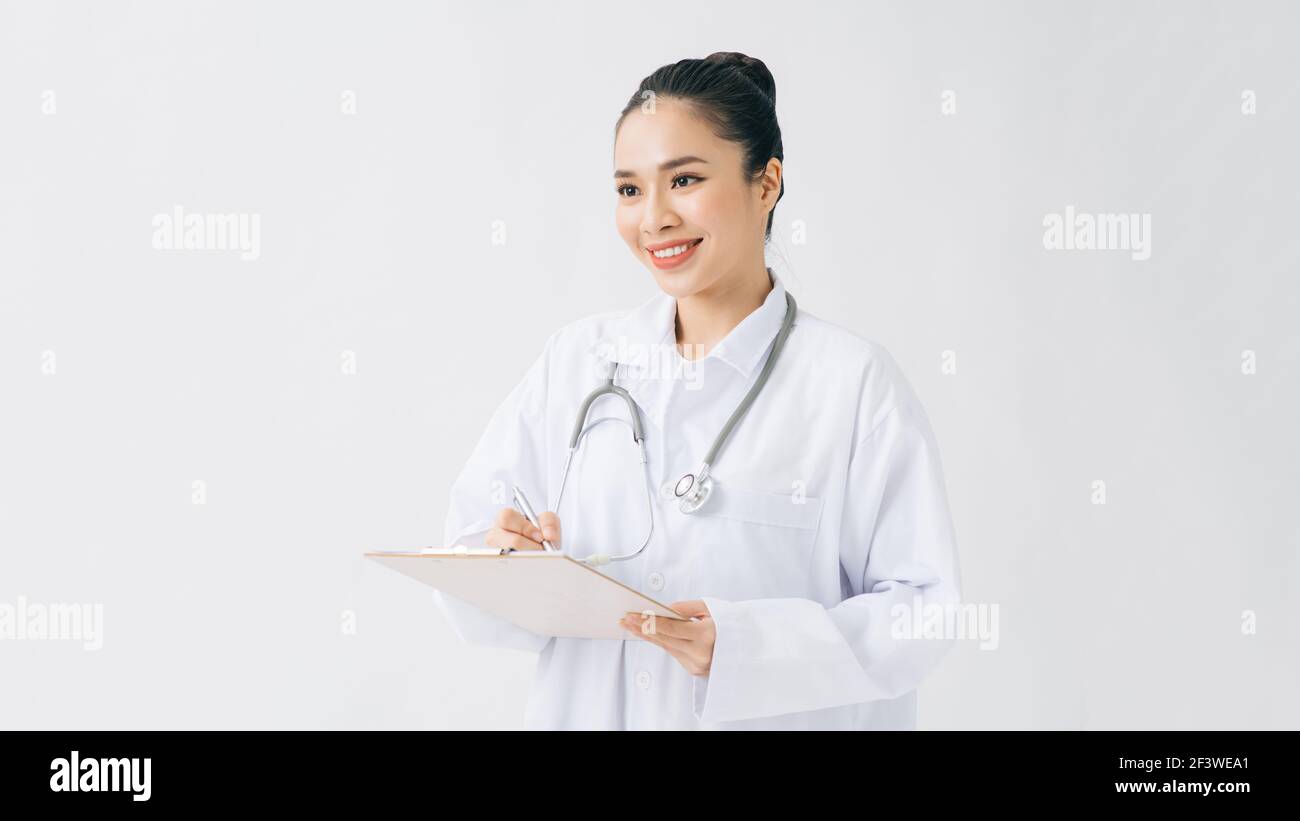 Side view of young asian female doctor writing on clipboard Stock Photo ...
