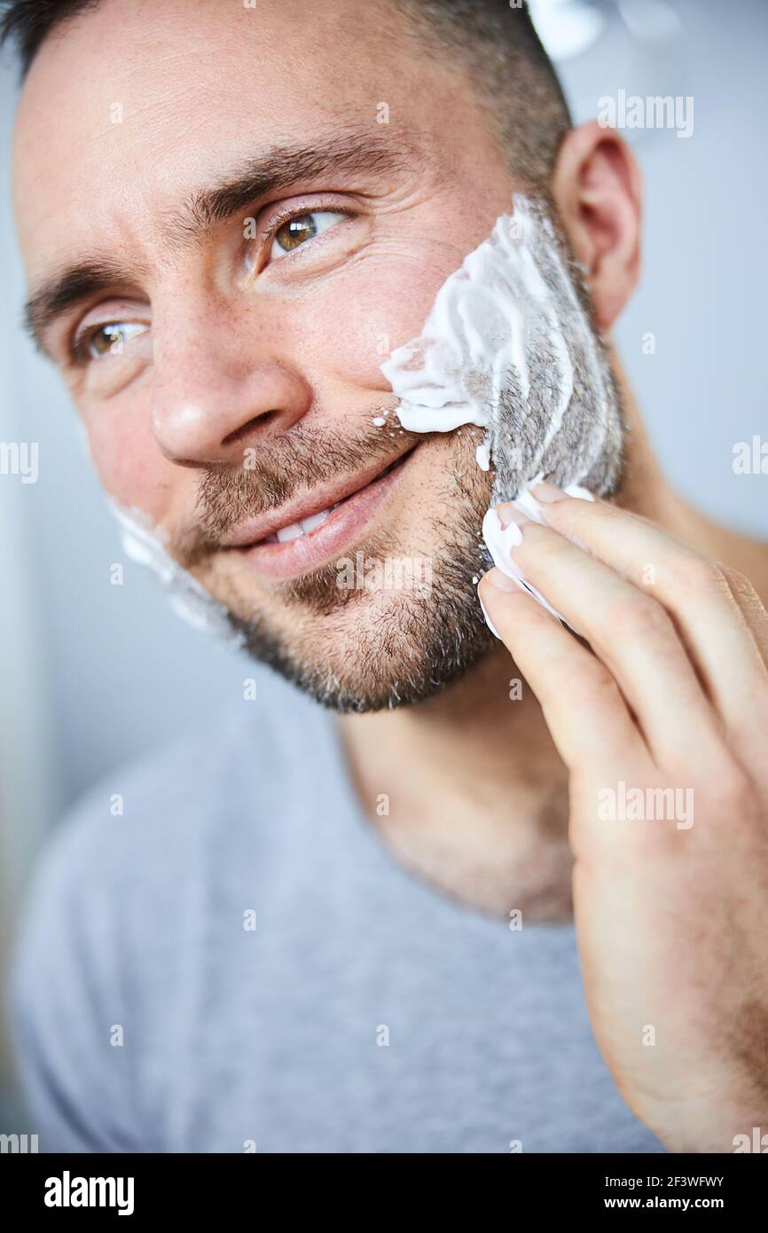 Young man applying shaving cream hi-res stock photography and images ...