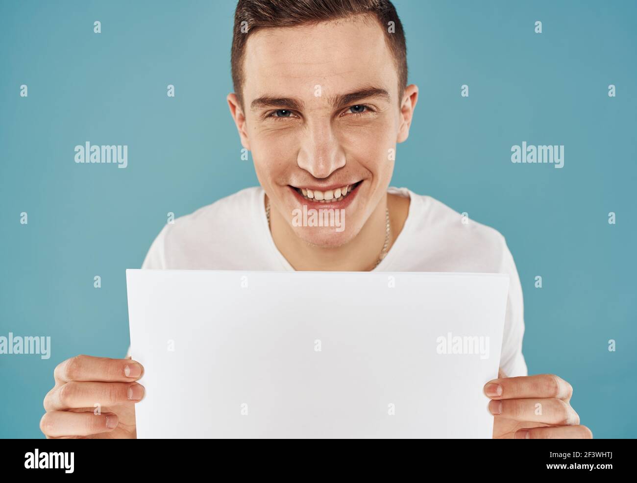 guy with flyer in hand Poster mockup blue background cropped view Stock ...