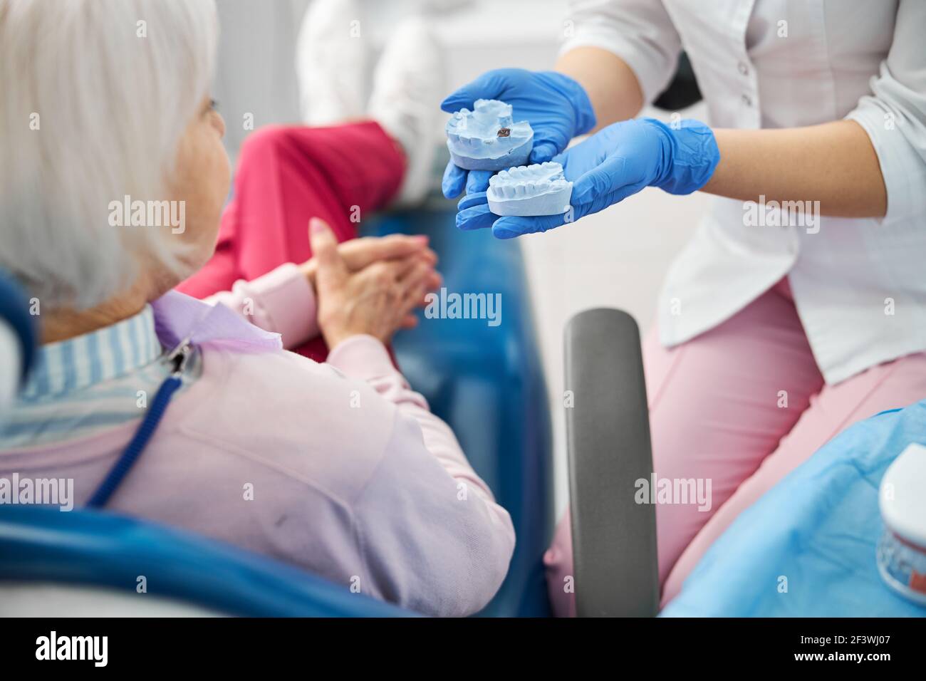 Adult giving a choice of two blue dental casts Stock Photo - Alamy