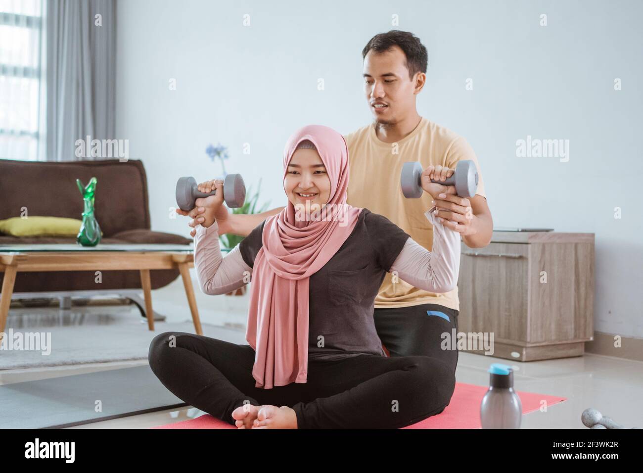 asian muslim couple exercising and lifting weight at home Stock Photo ...