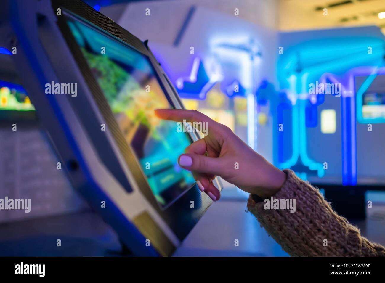 Woman hand using touchscreen display of floor standing tablet kiosk ...