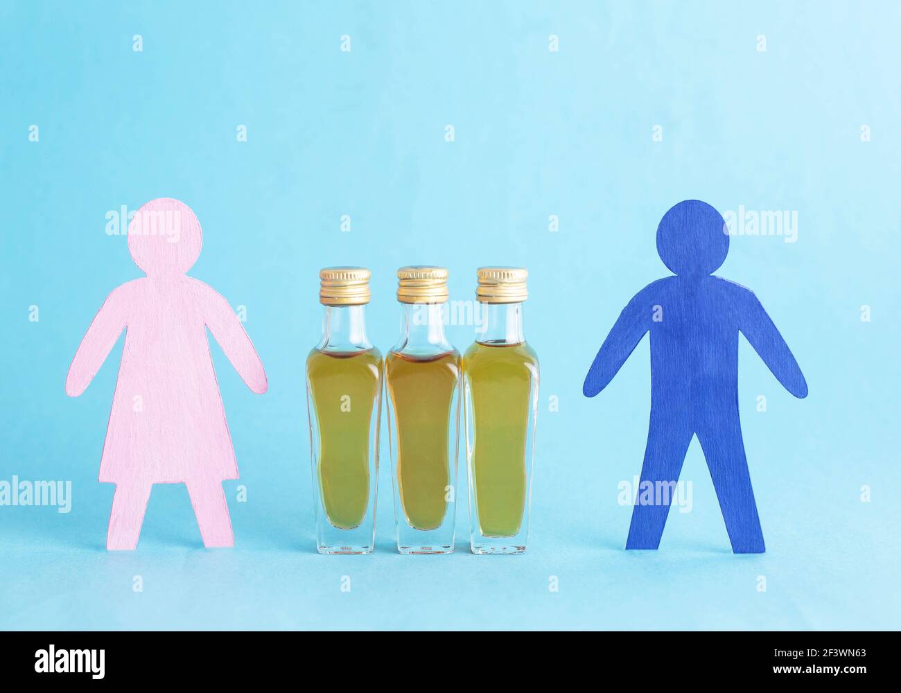 Wooden figures of a man and a woman on a blue background with bottles ...
