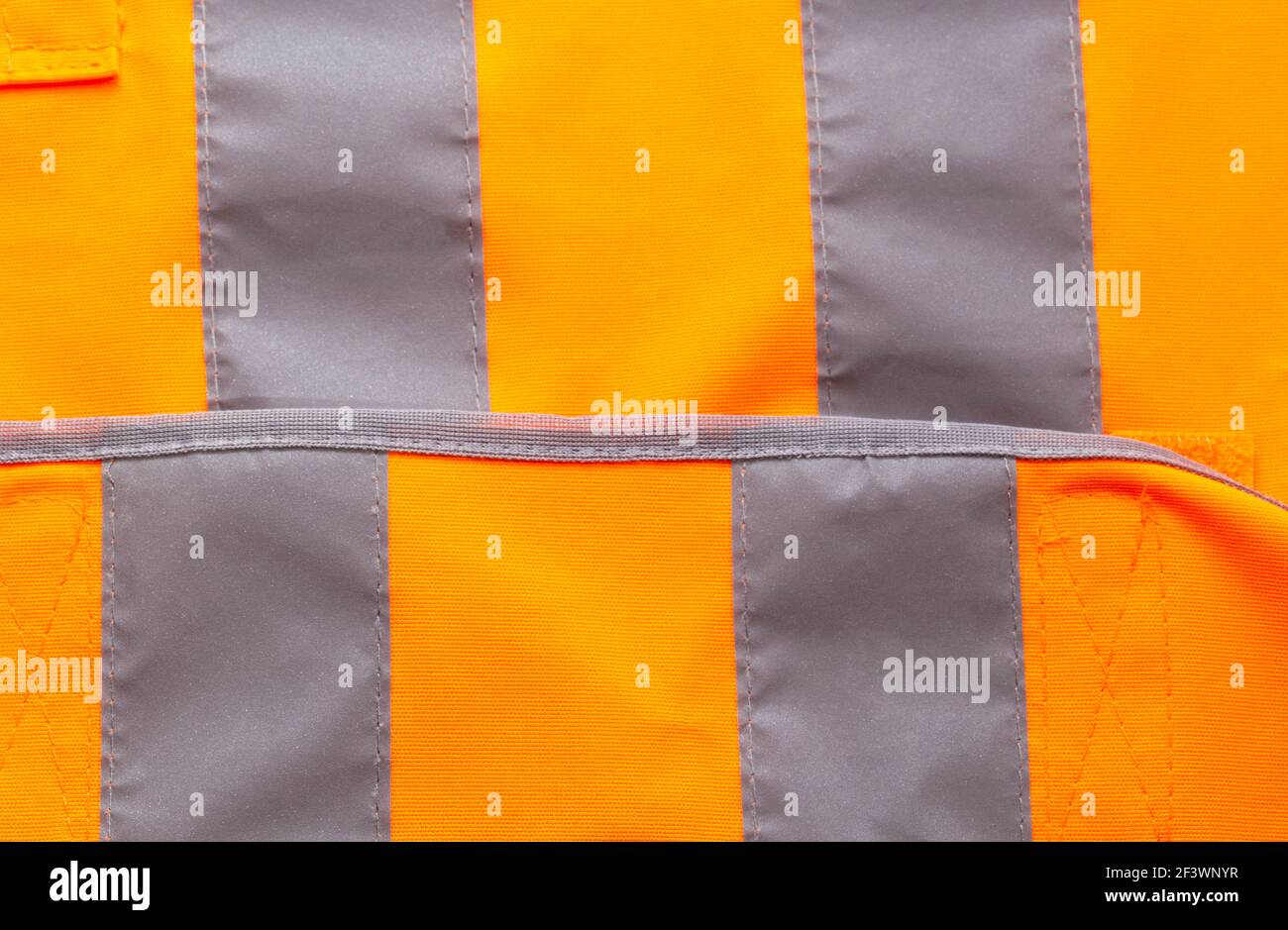 Orange signal vest with silver reflective tape, macro Stock Photo - Alamy