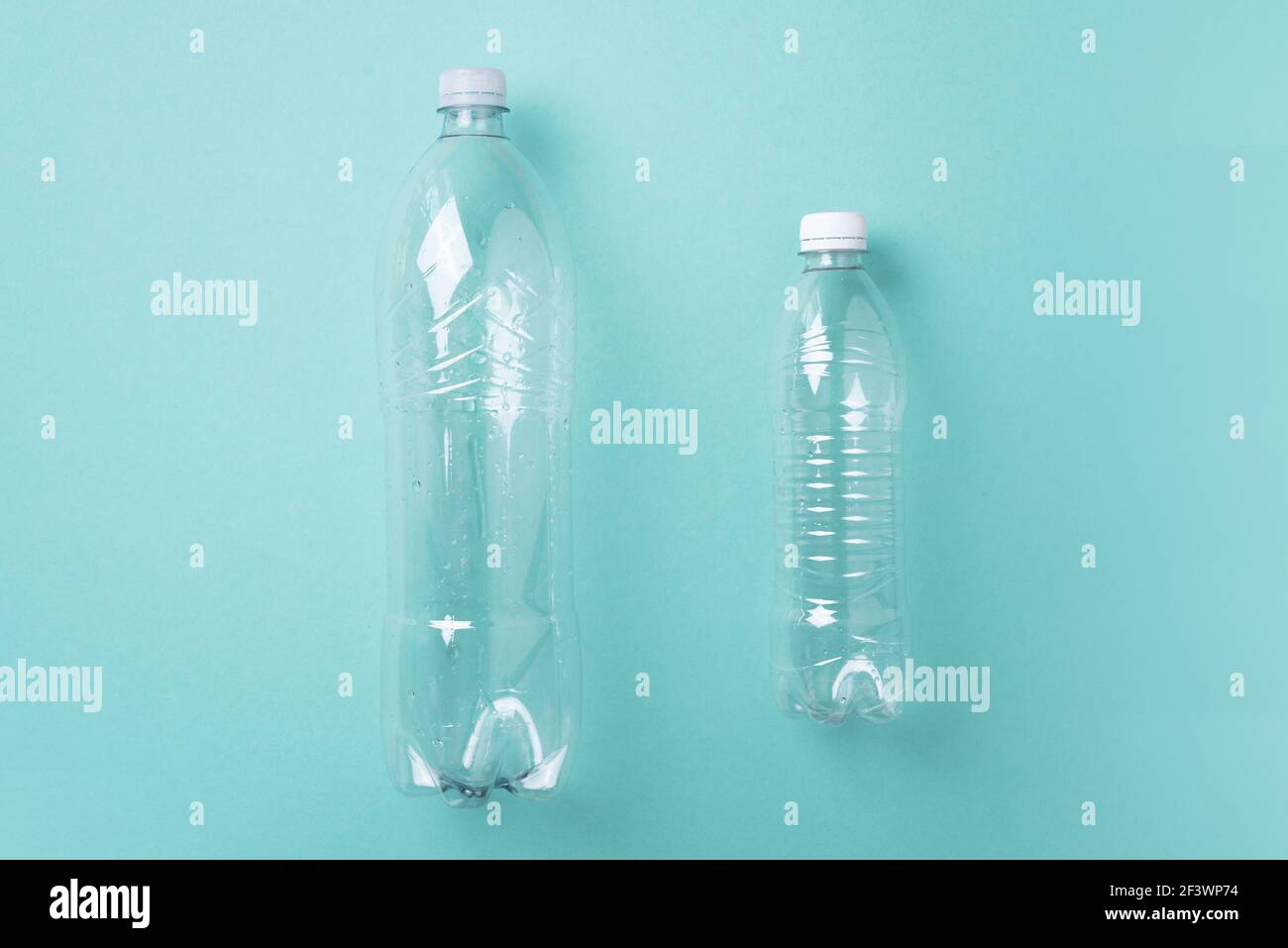 Empty rumpled used plastic bottle on blue background. Top view, copy ...