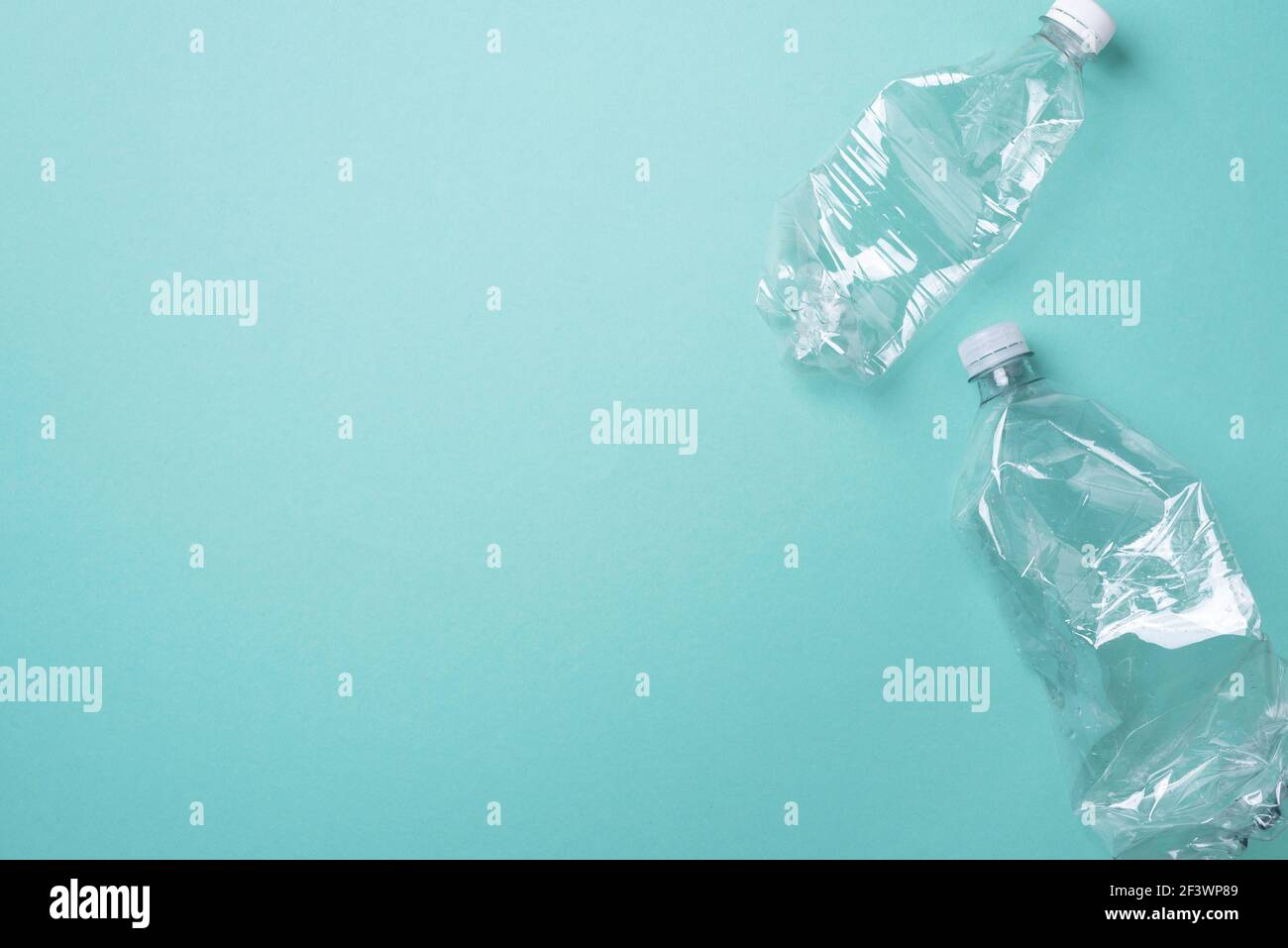 Empty rumpled used plastic bottle on blue background. Top view, copy ...