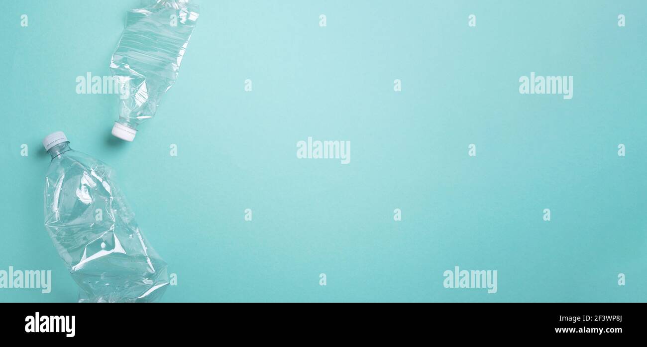 Plastic empty rumpled bottles on a blue background. Top view, copy ...