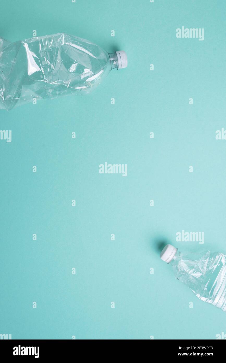 Empty rumpled used plastic bottle on blue background. Top view, copy ...