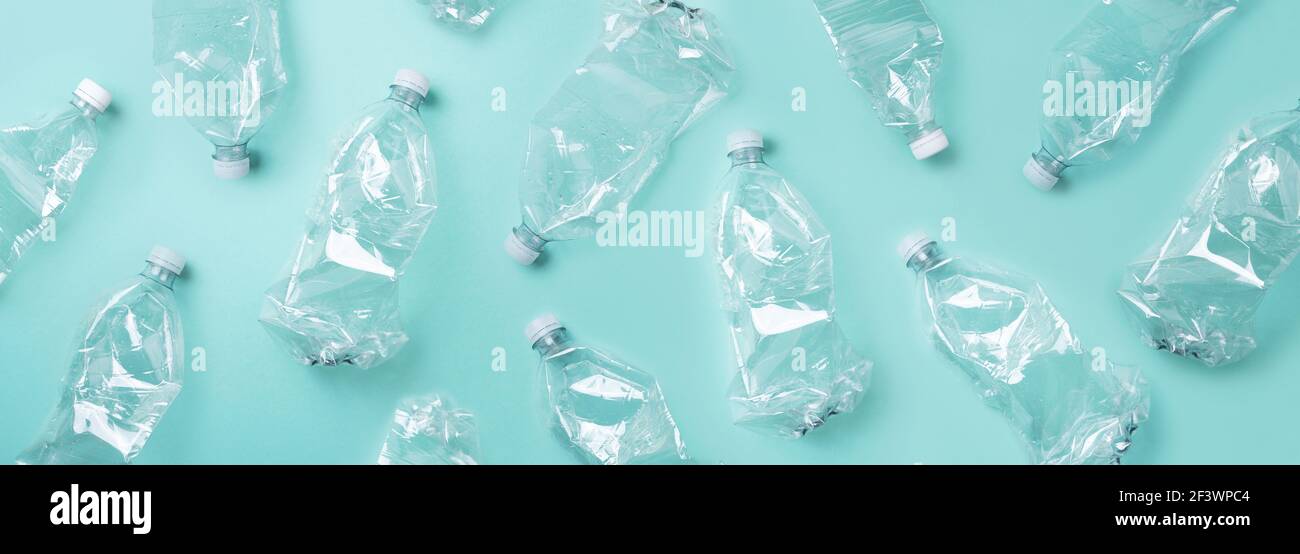 Empty rumpled used plastic bottle on blue background. Top view, copy ...