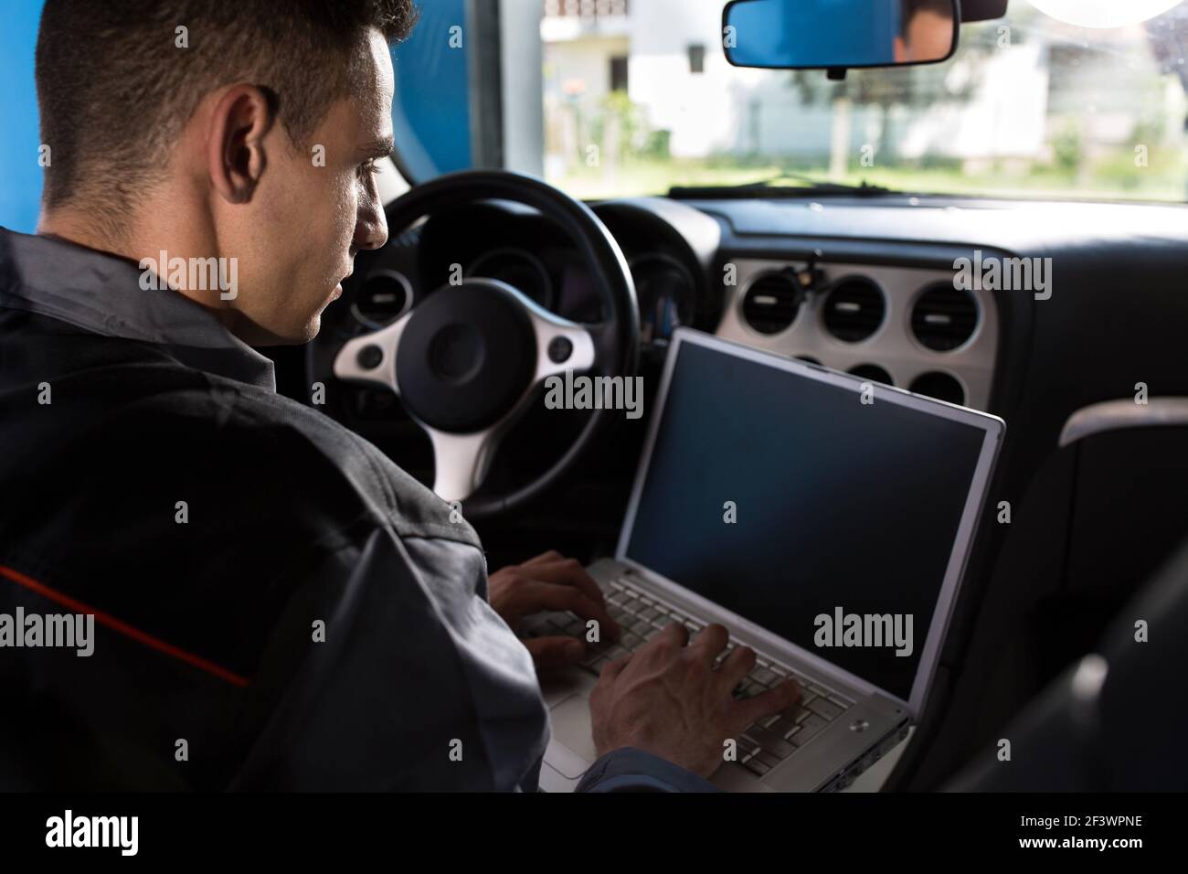 Mechanic check the electronics with laptop, looking diagnostic problem ...