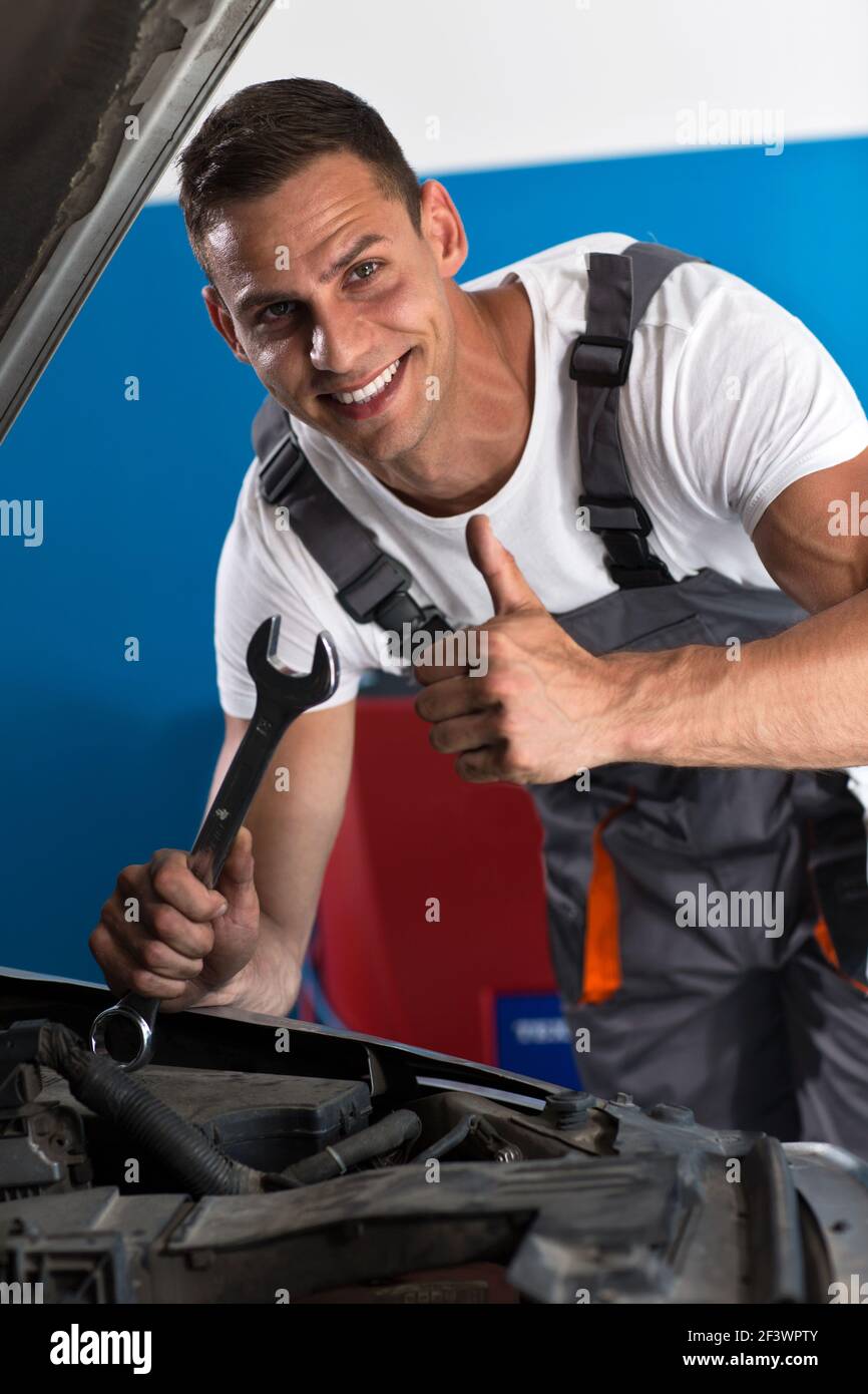 smiling successful mechanic in a workshop finger up Stock Photo - Alamy
