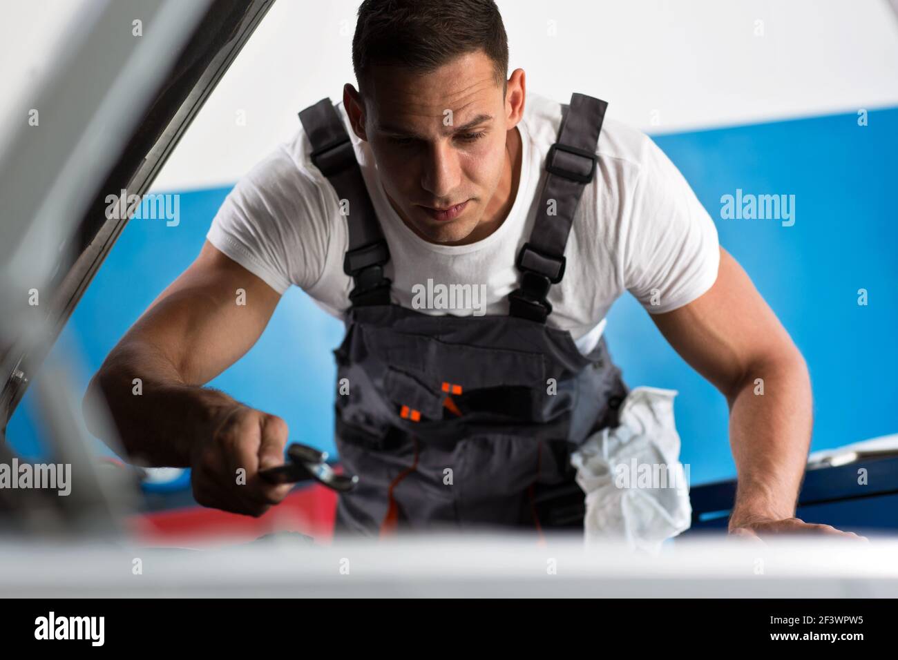 Young mechanic fixing automotive engine Stock Photo - Alamy