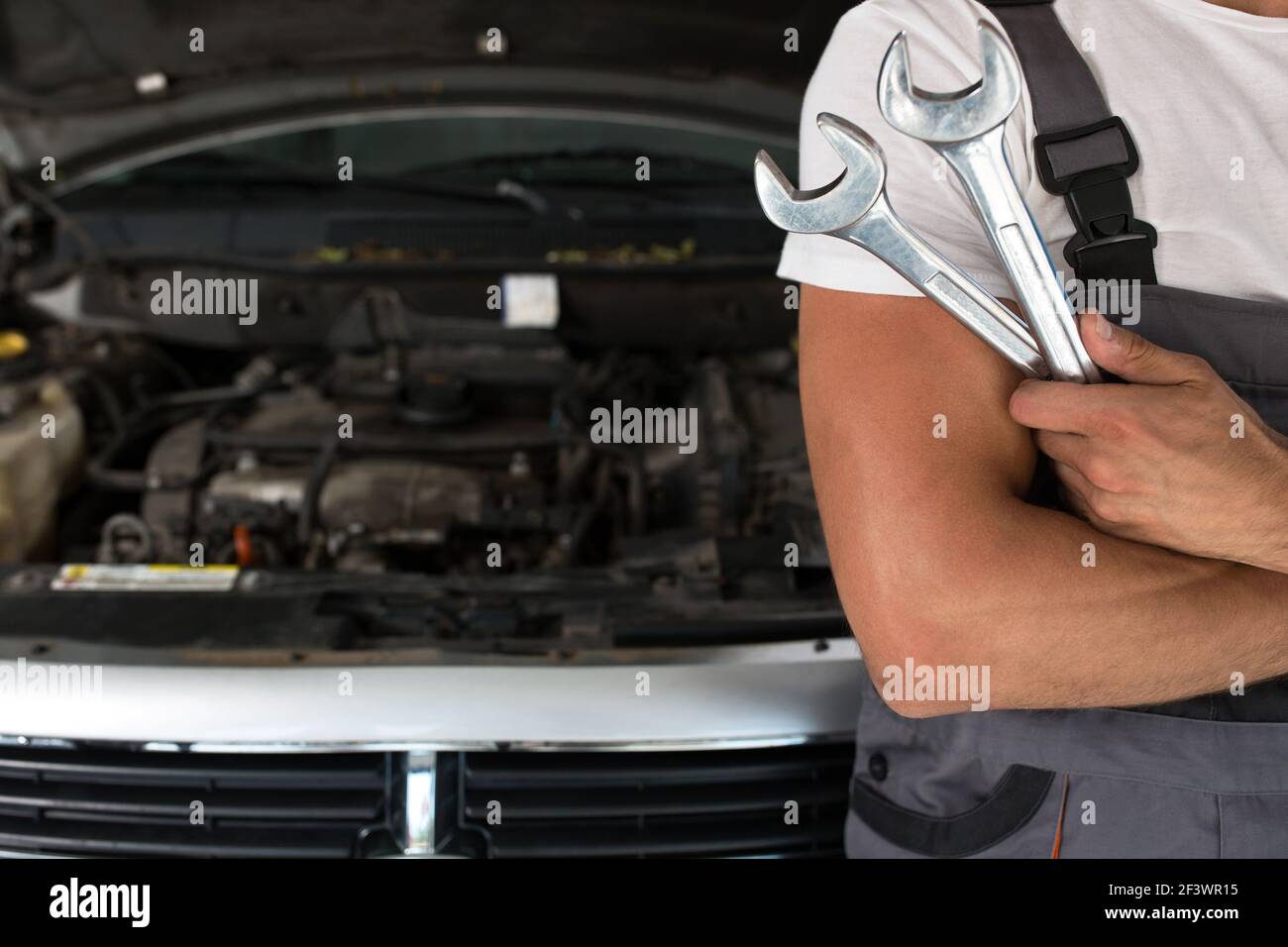 Mechanic hands with two wrench close up Stock Photo - Alamy
