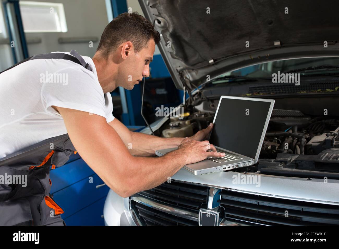 Mechanic using laptop to diagnostic malfunction at car Stock Photo - Alamy