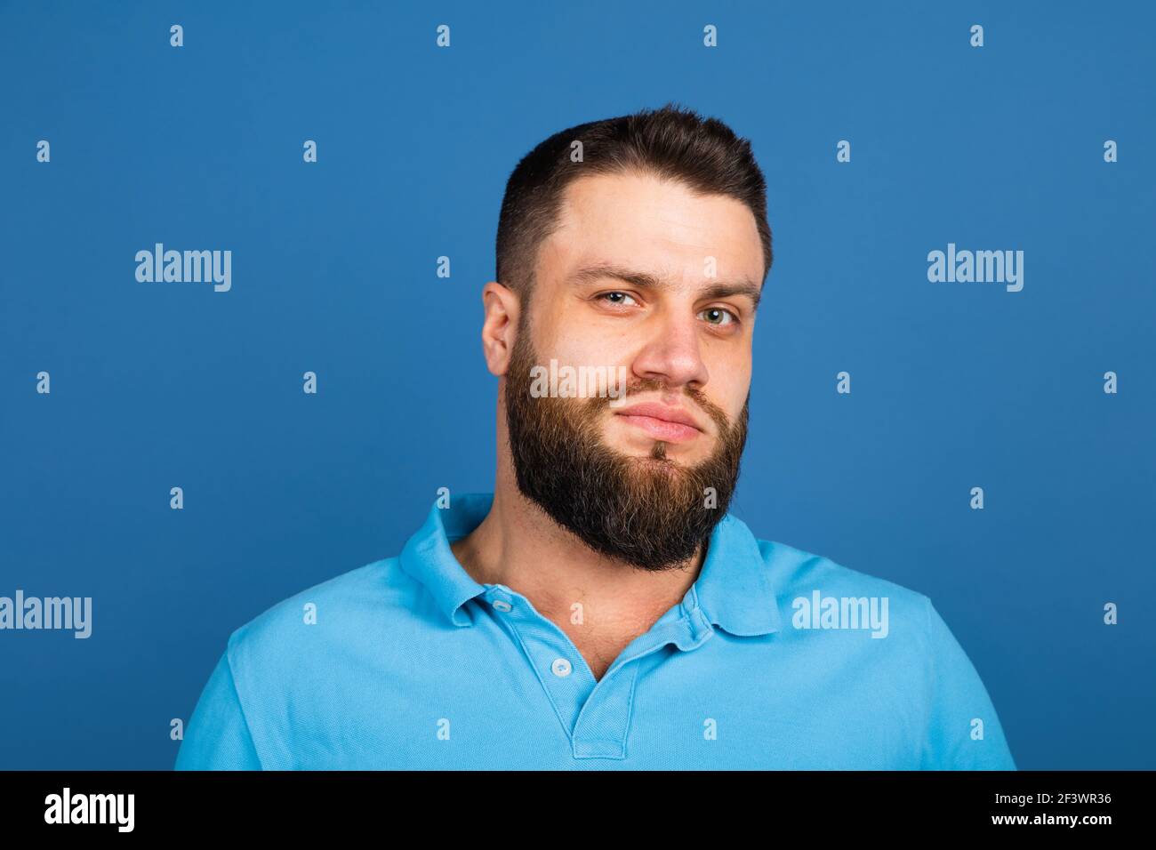 Caucasian man's portrait isolated on blue studio background with ...