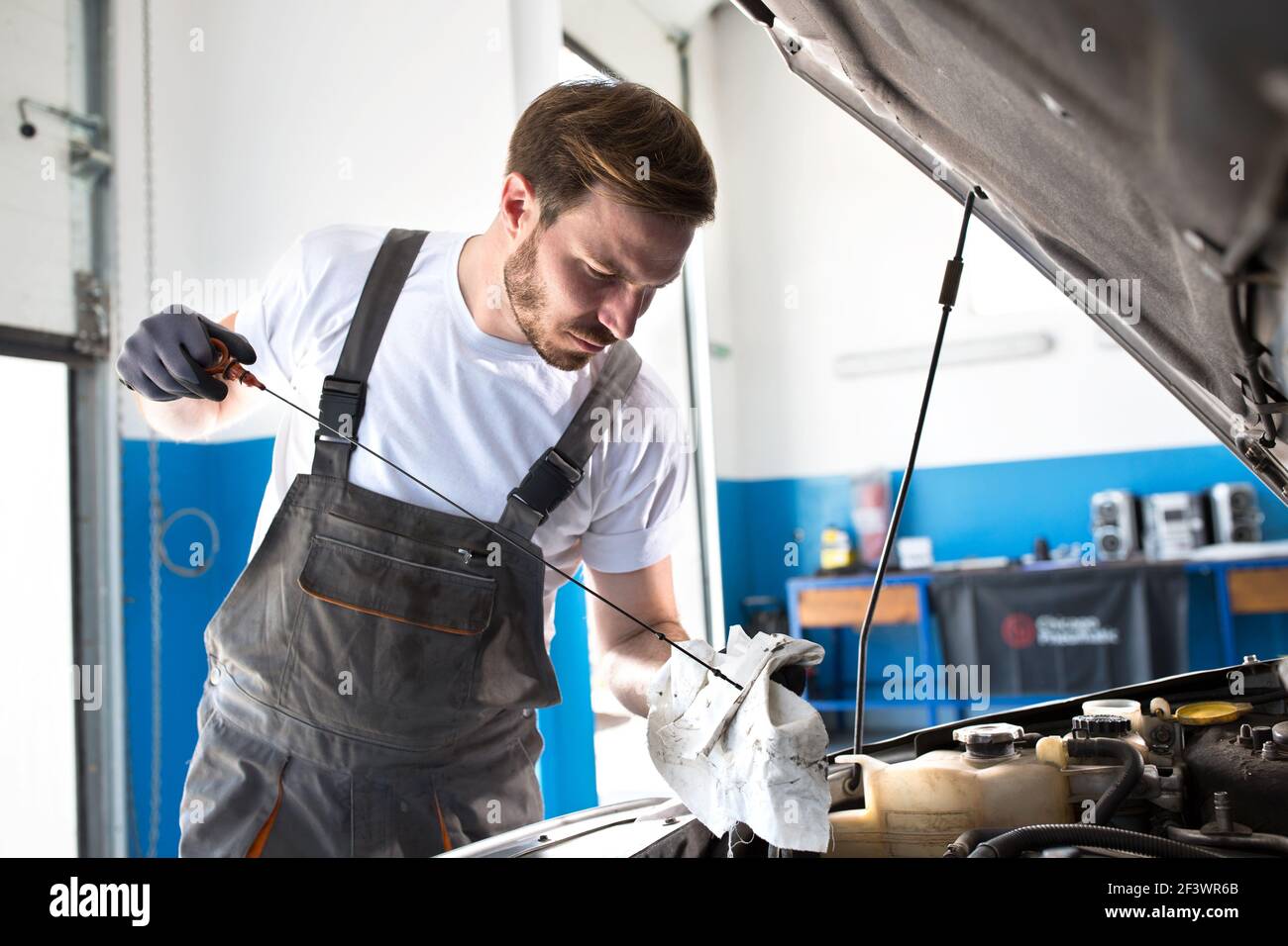 Mechanic checking oil level in the car Stock Photo - Alamy