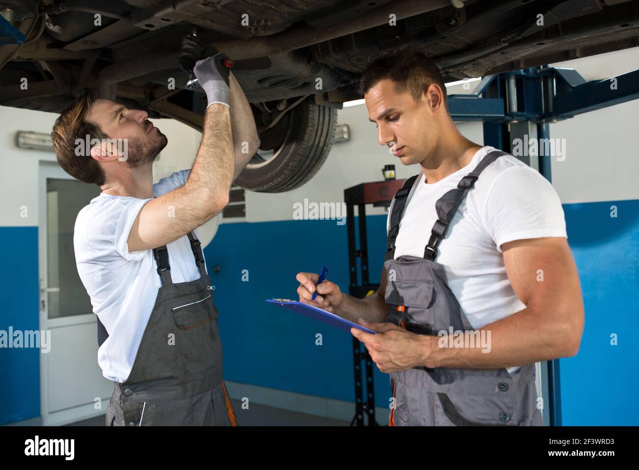 Team of mechanics changing the screws at workstation Stock Photo - Alamy