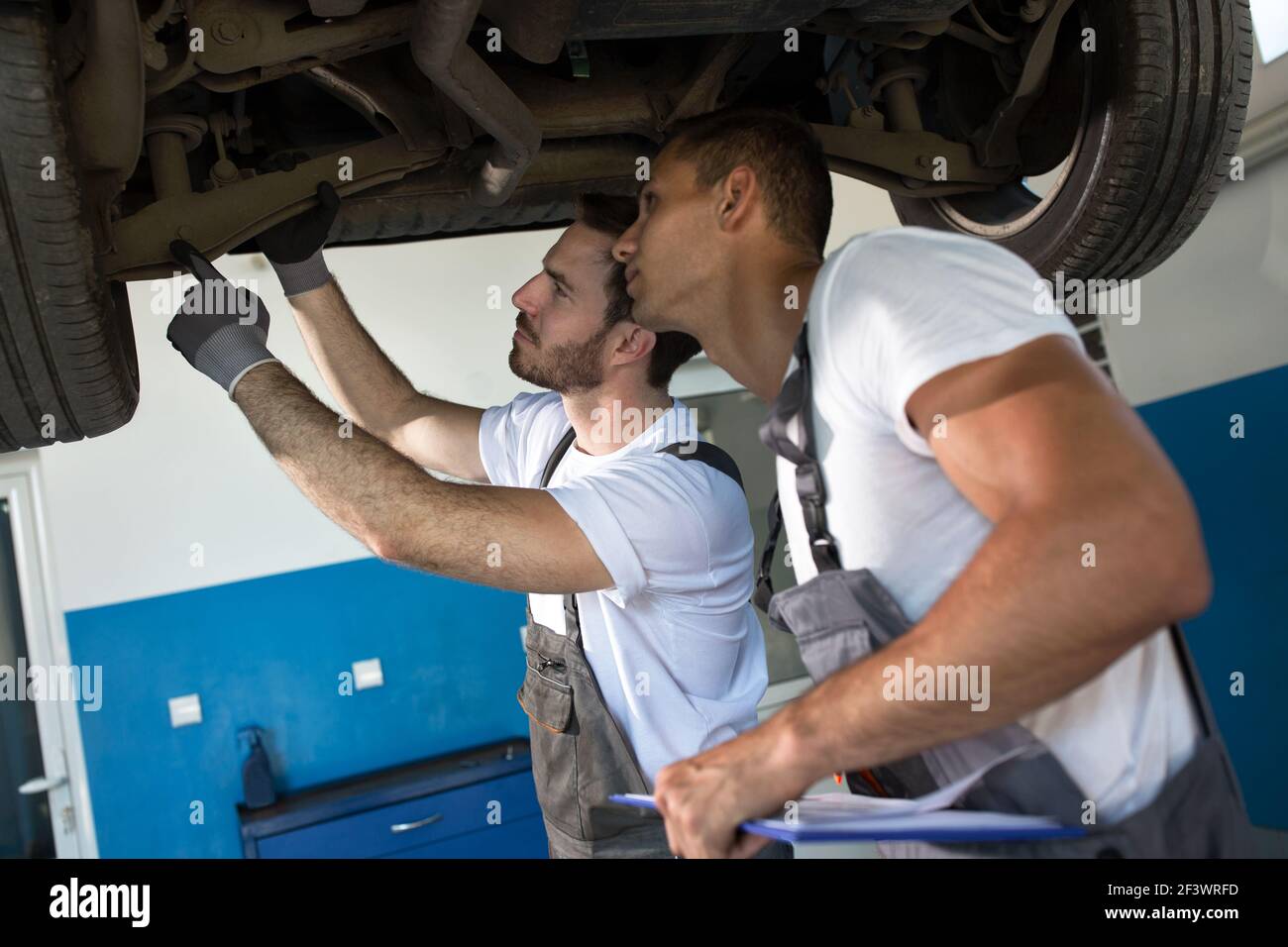 Mechanics cheking and control car together at workshop Stock Photo - Alamy