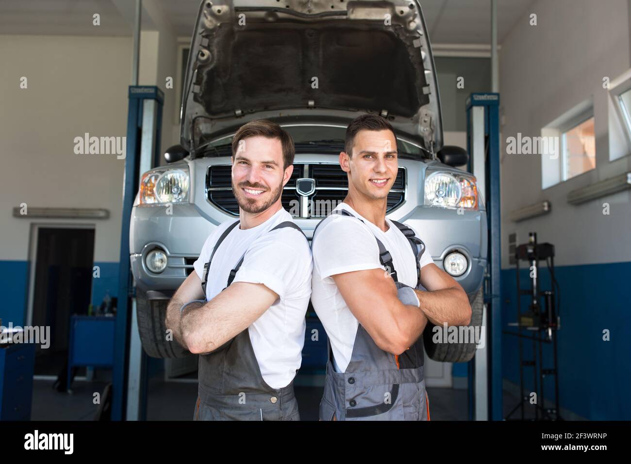 Team of smiling success mechanics at the auto service garage Stock ...