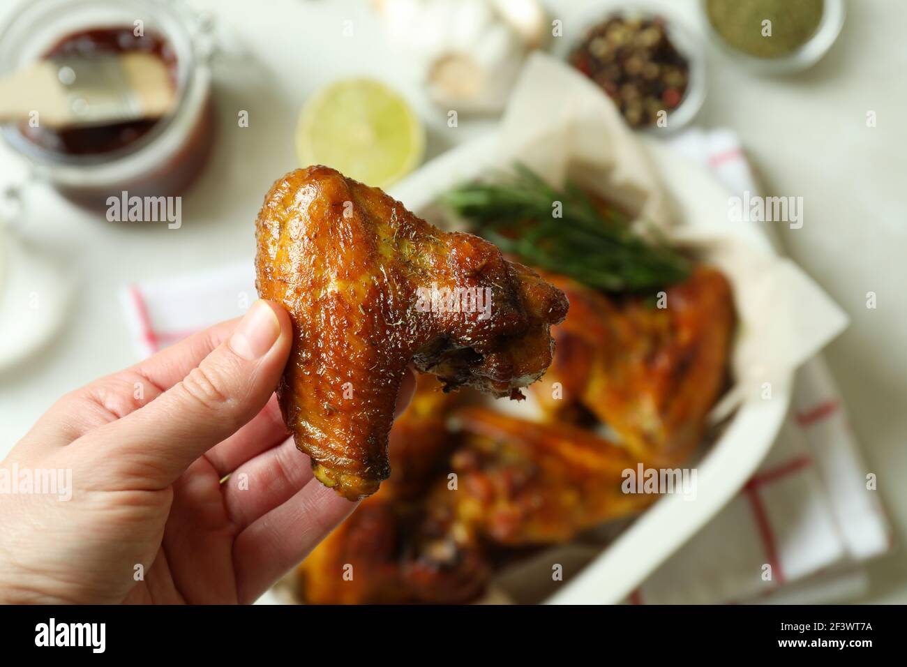 Female hand hold baked chicken wing, close up Stock Photo - Alamy