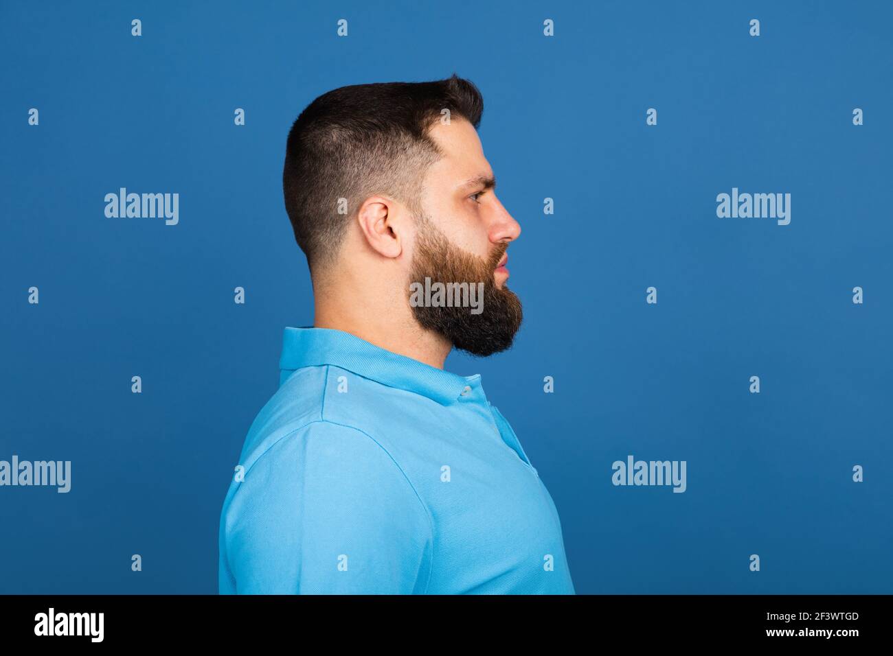 Caucasian man's portrait isolated on blue studio background with ...