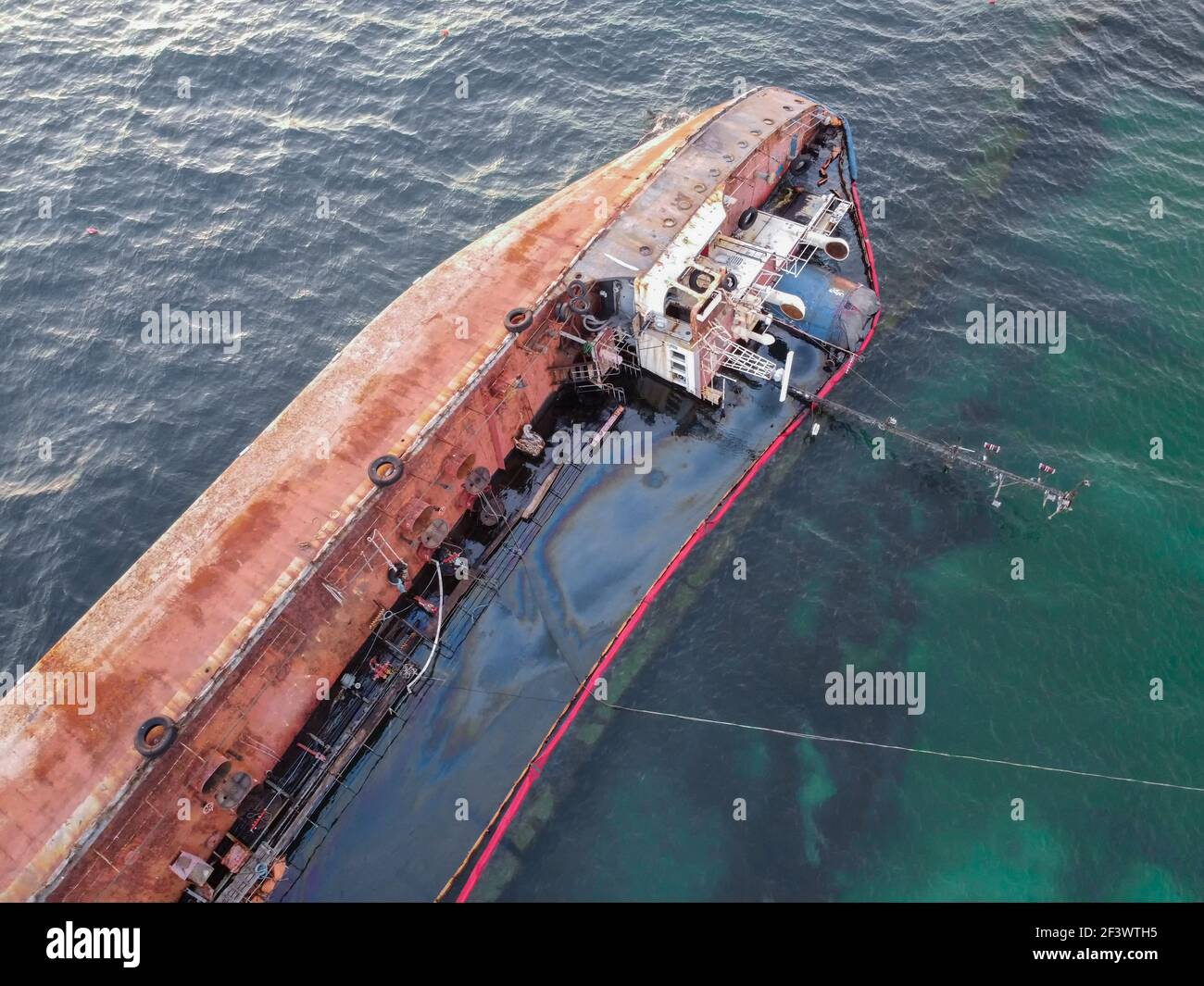 An old rusty tanker lies on the beach sideways. The storm-swept vessel ...