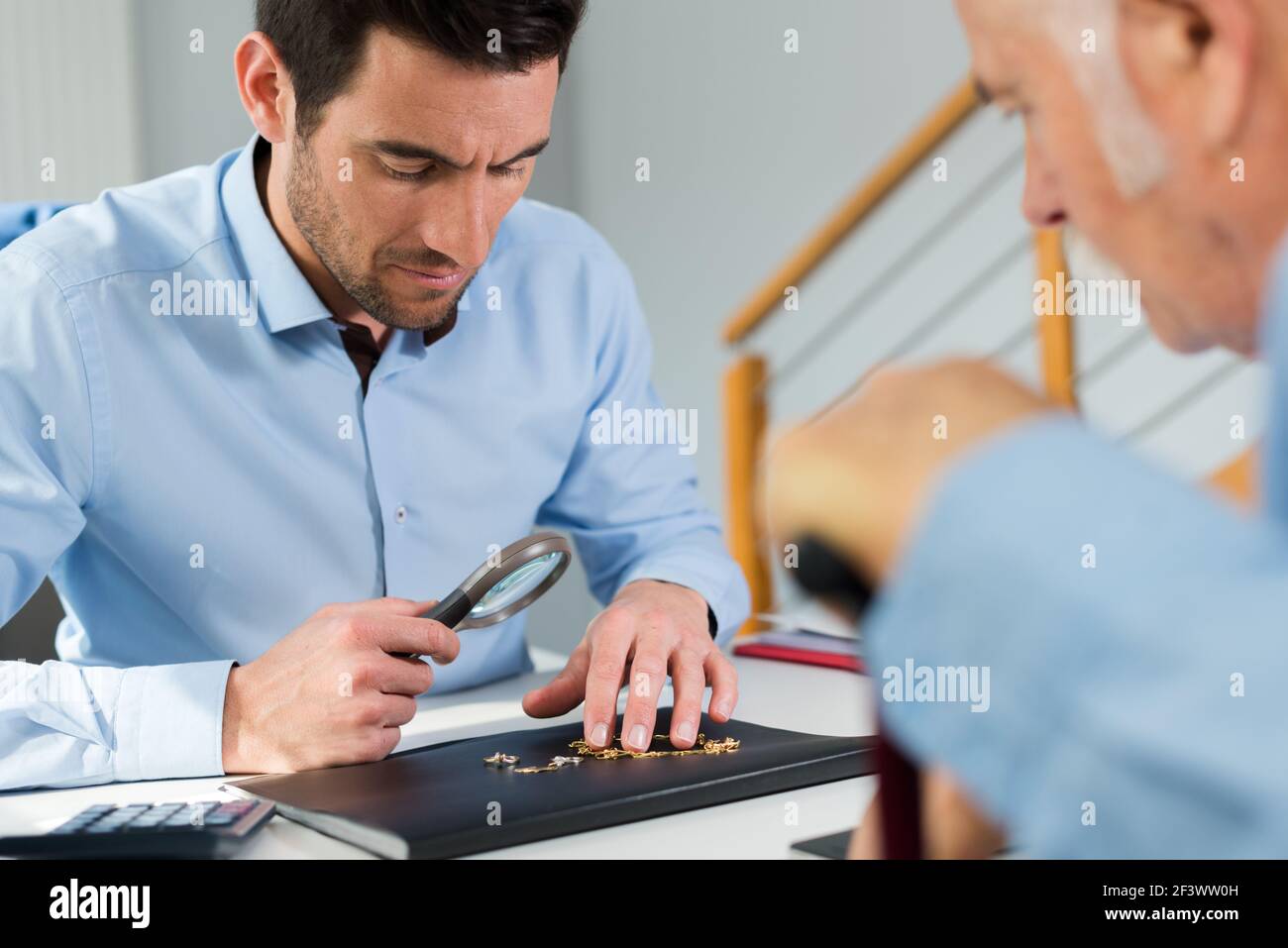 jeweler looking at diamond through loupe to inspect it Stock Photo - Alamy