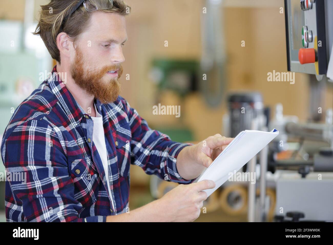 workman reading instructions for setting-up factory machine Stock Photo ...
