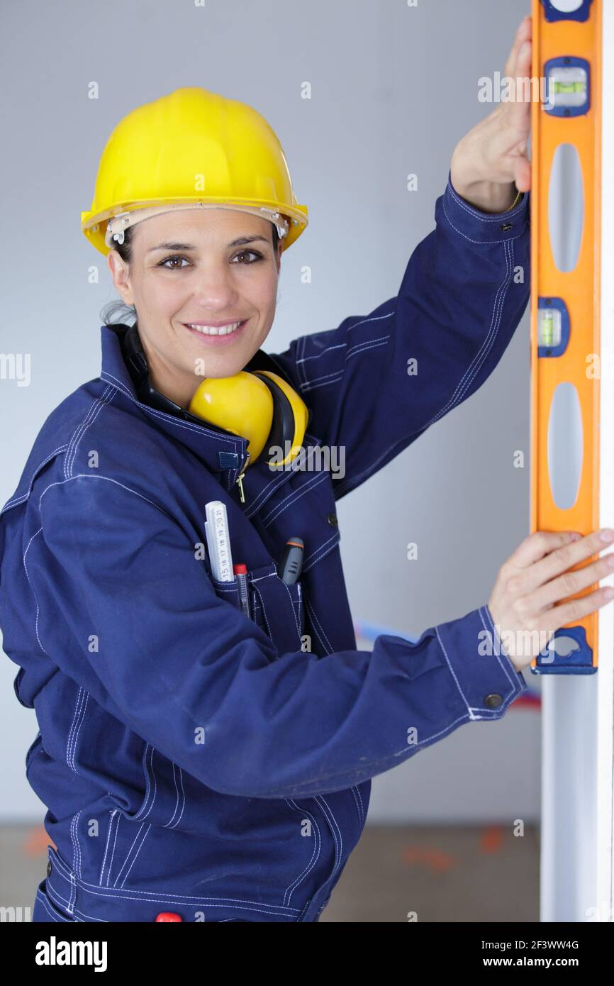 female builder using a spirit level Stock Photo - Alamy