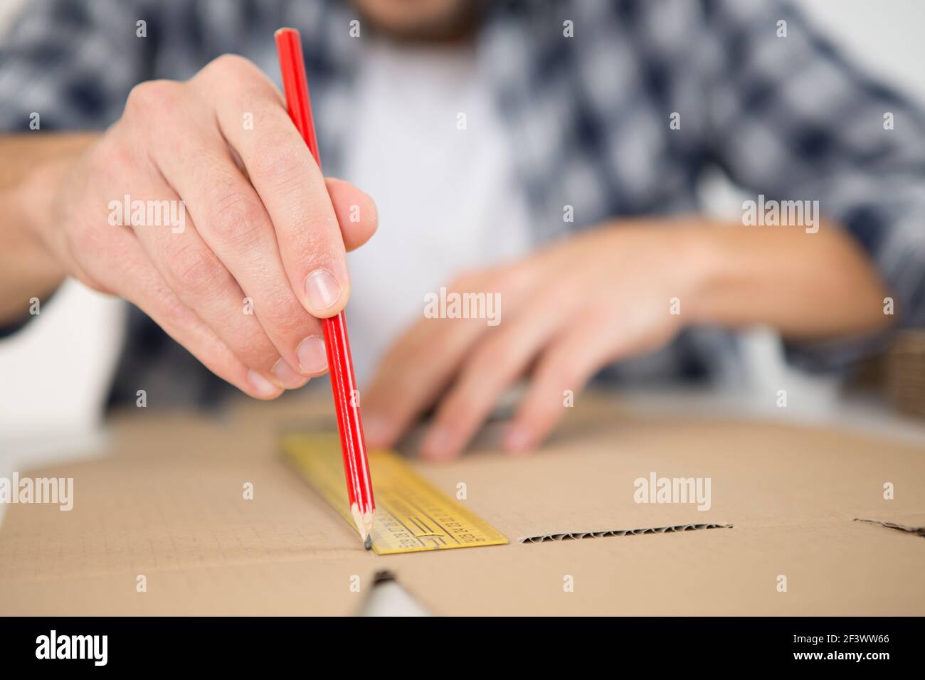 packaging designer drawing a line on cardboard Stock Photo - Alamy