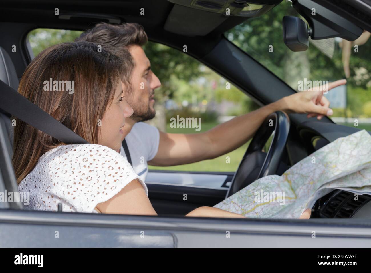 couple driving and using a map to navigate Stock Photo - Alamy