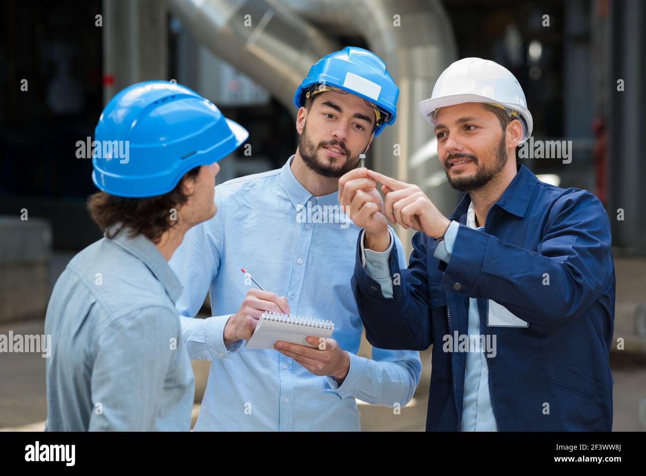 engineer showing a screw to his interns Stock Photo - Alamy