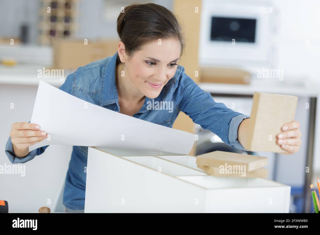 confident woman following instructions to assemble furniture Stock ...
