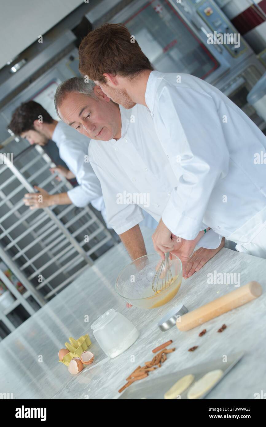 baker giving advice to a young apprentice Stock Photo - Alamy