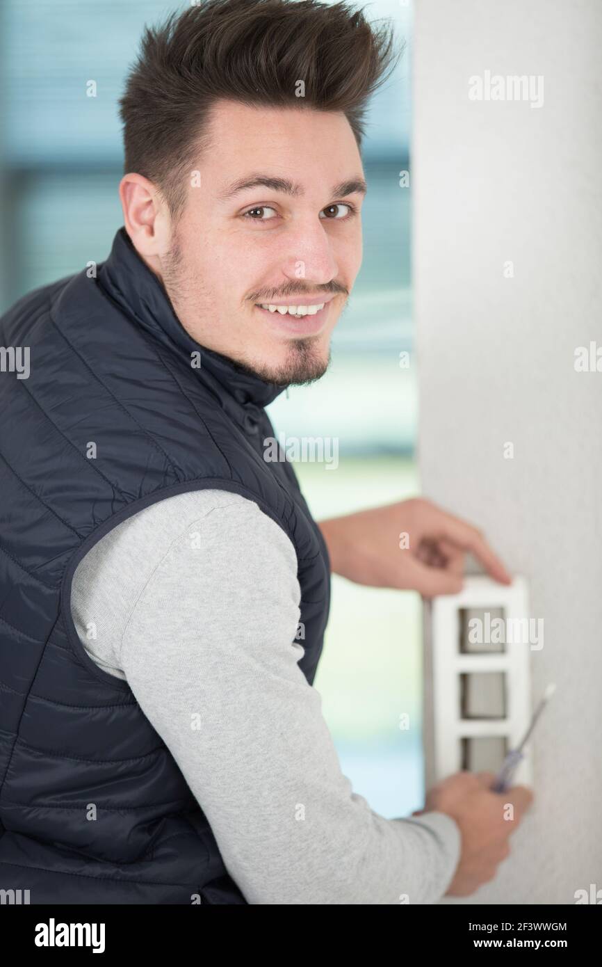 man install lightswitch on the wall Stock Photo - Alamy