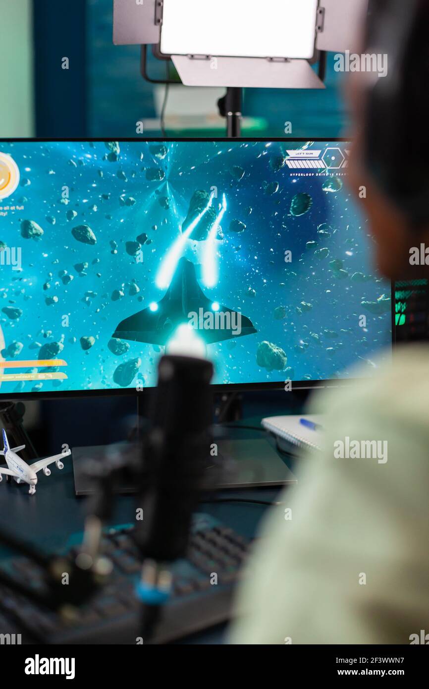 Back shot of esports streamer playing space shooter game during live ...