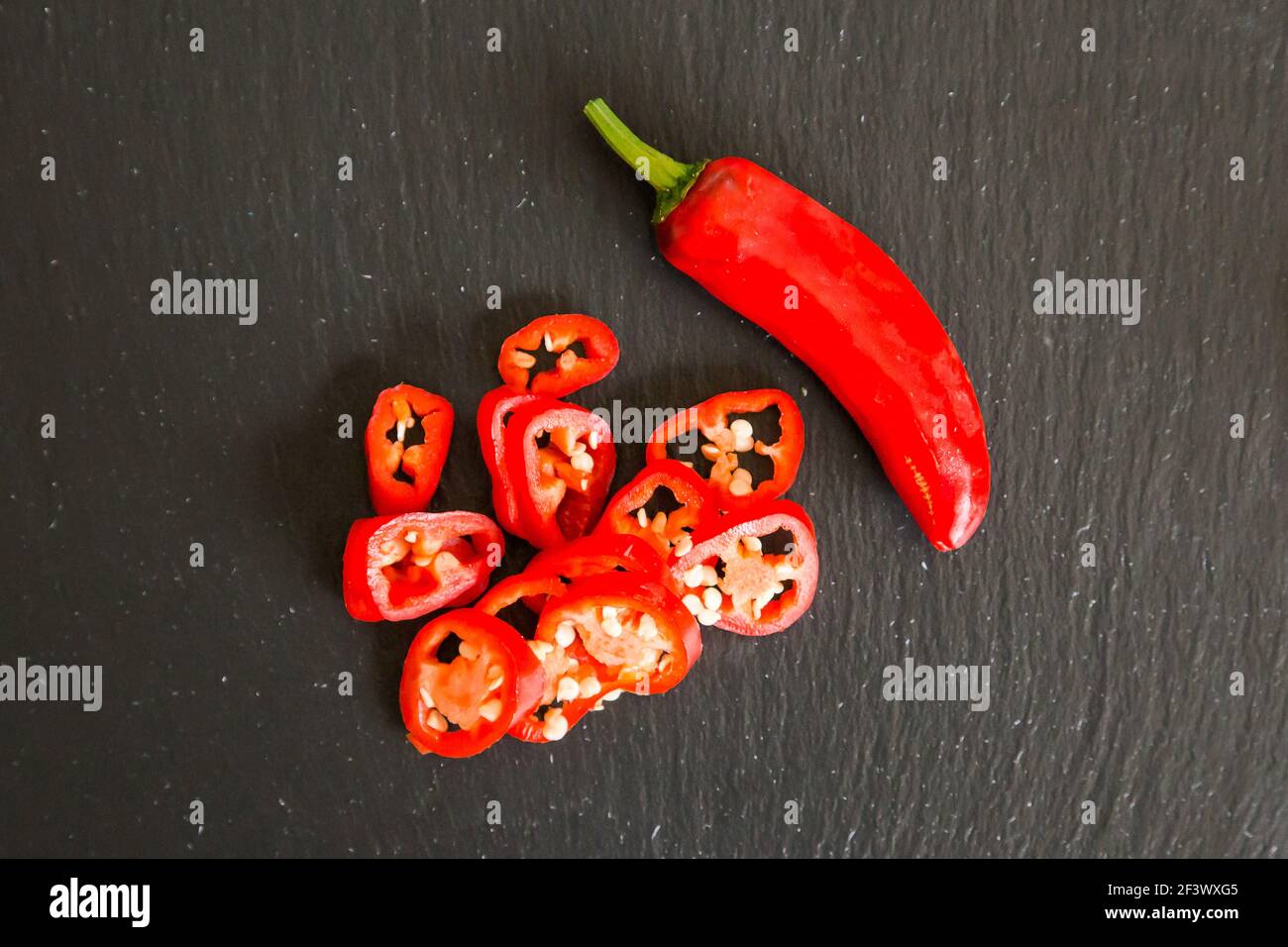 A flat lay of chopped chili on dark background Stock Photo - Alamy