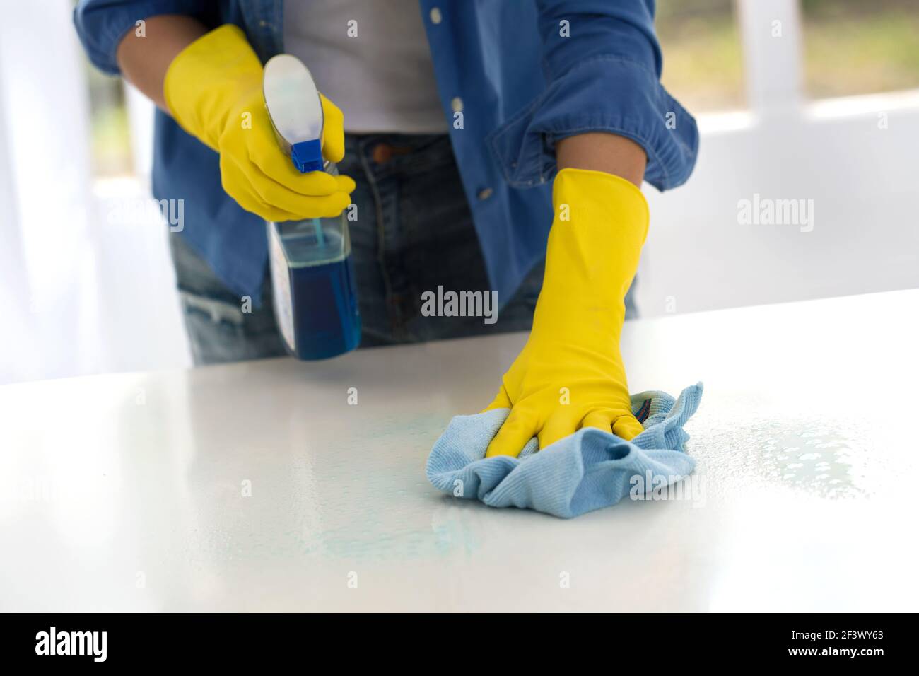 Worth girl cleaning the table with mop Stock Photo - Alamy