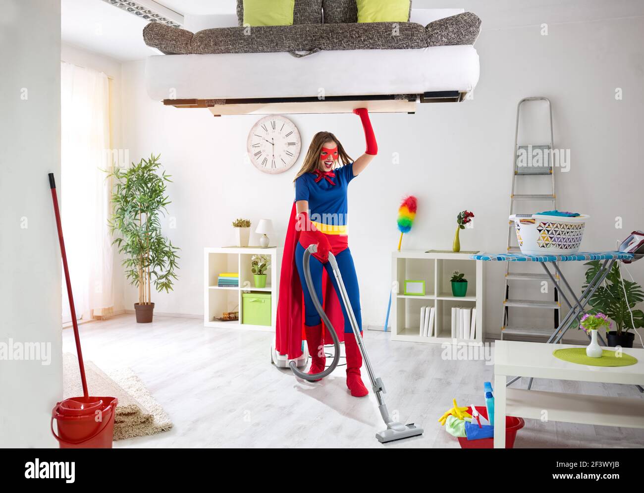 Strong super hero housewife cleaning home and holding bad in the air ...