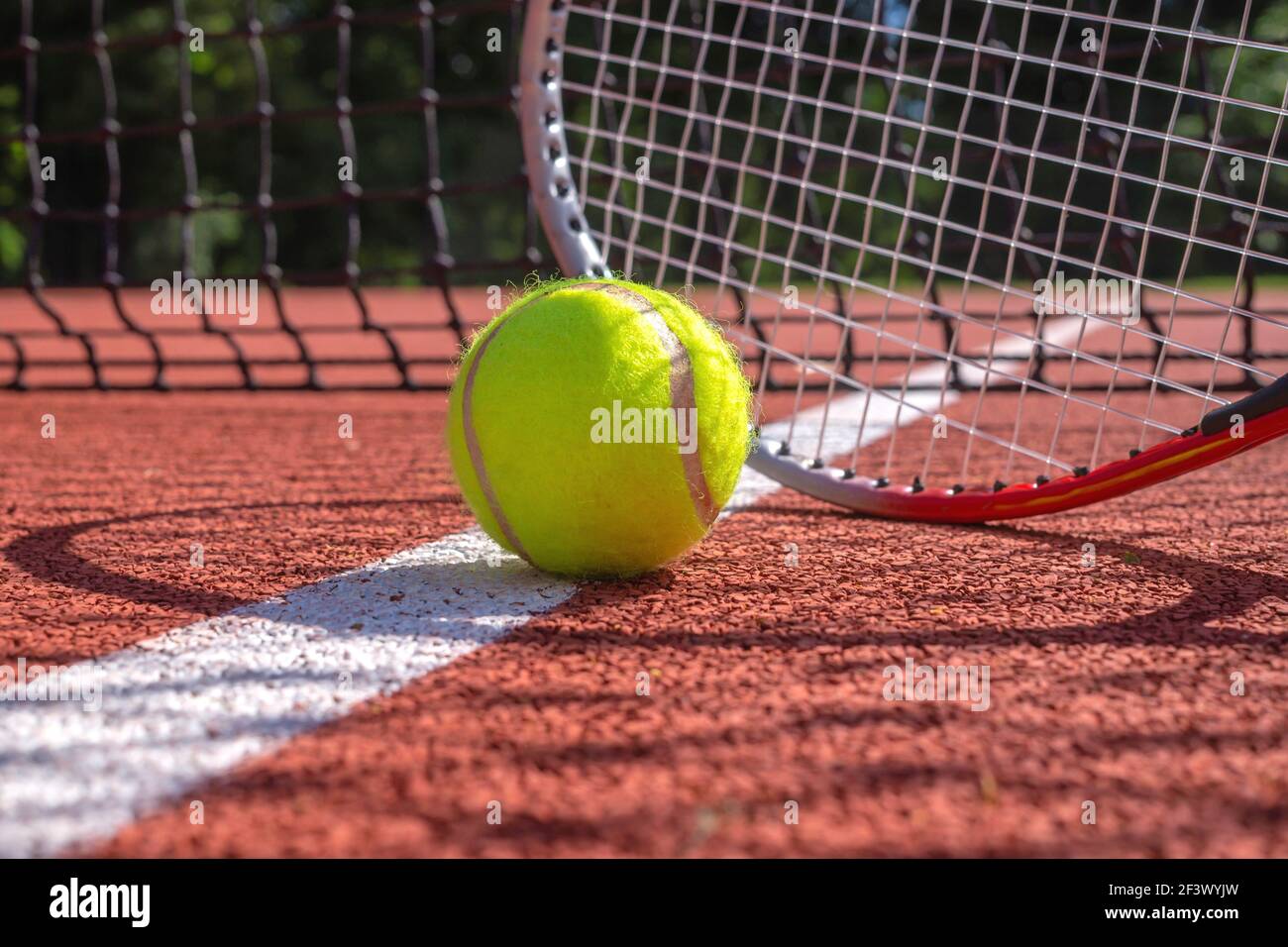 Tennis ball, line and racket on an outdoor court with the racket ...