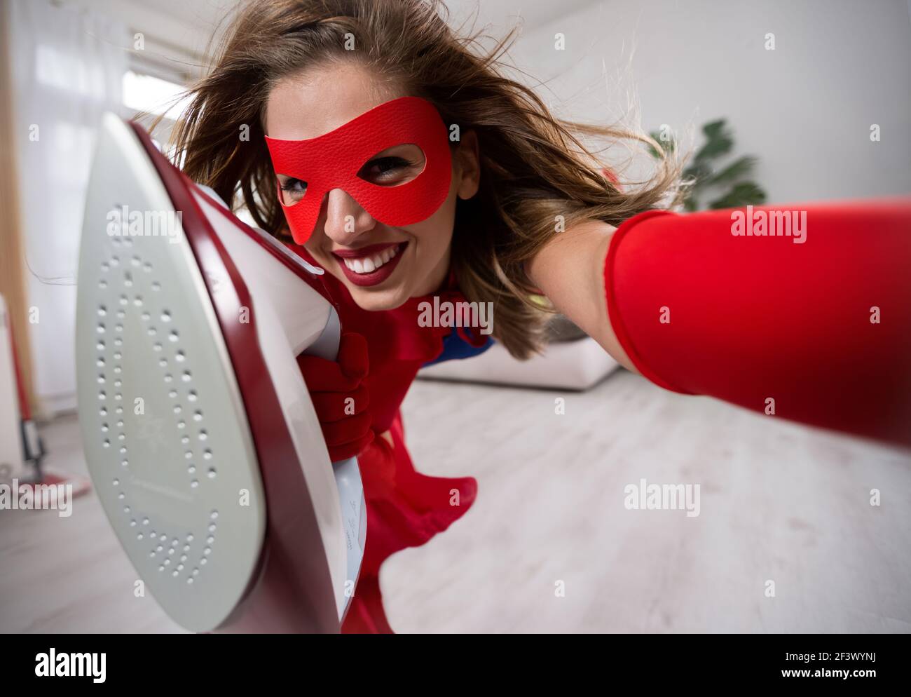 Woman superhero flying through the room with iron Stock Photo - Alamy