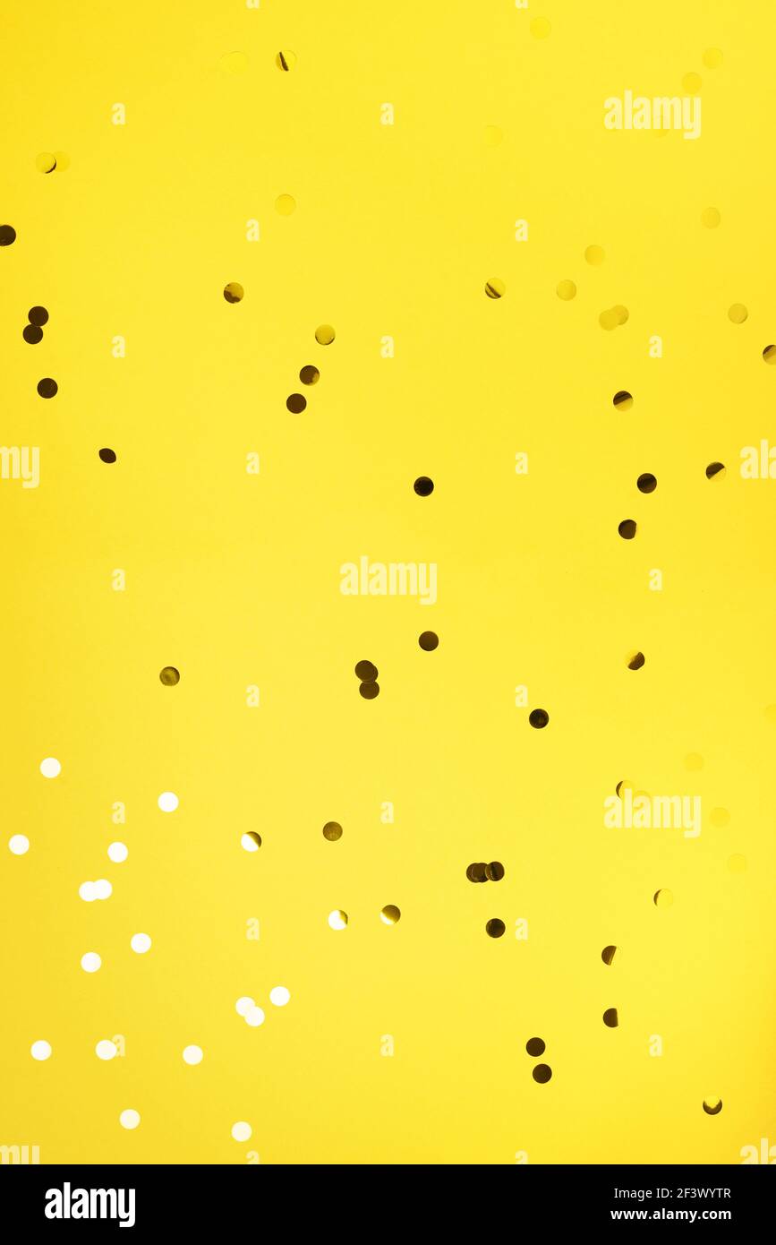 Golden confetti on yellow background with light bokehs. Happy new year ...