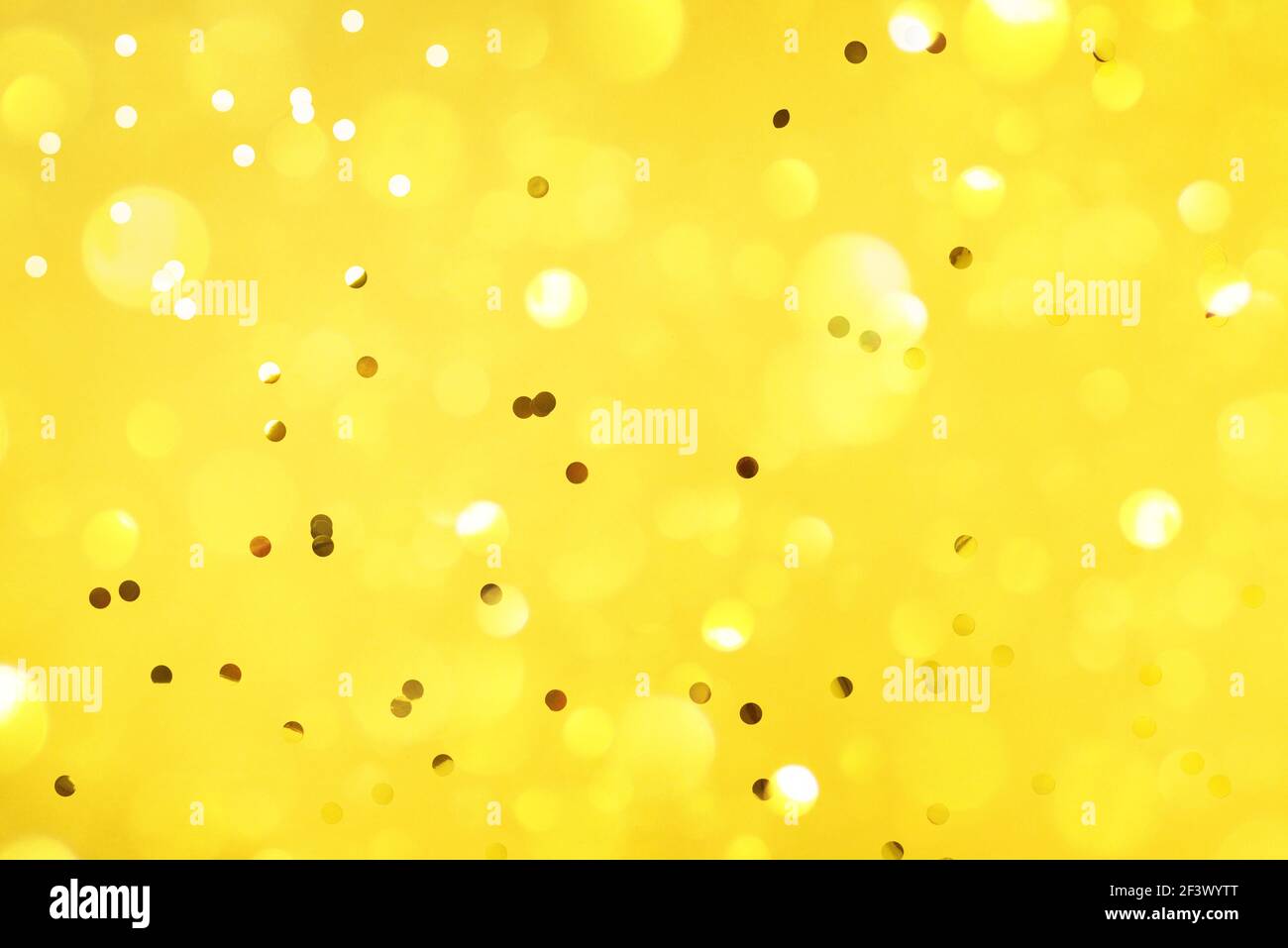 Golden confetti on yellow background with light bokehs. Happy new year ...