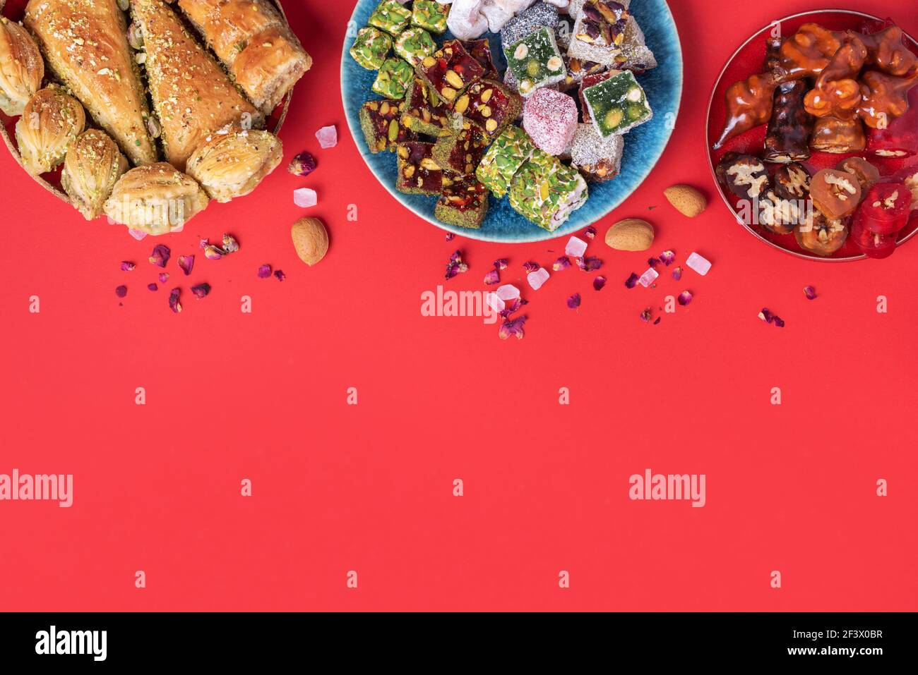 Middle Eastern sweets on red background. Arab dessert, baklava, halva ...