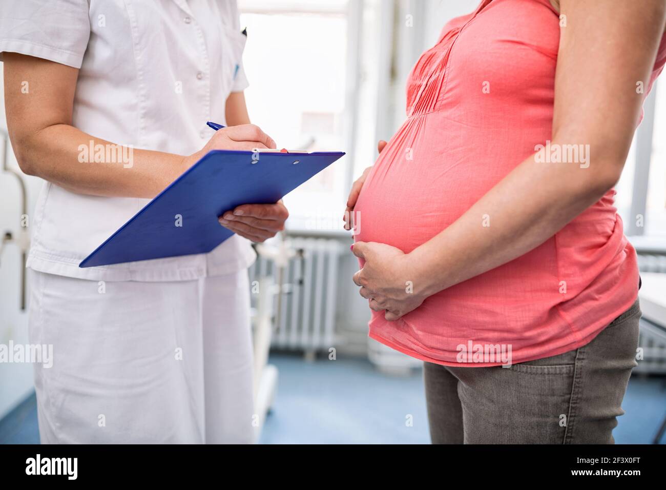 Nurse checking weight of pregnant woman in hospital room Stock Photo ...