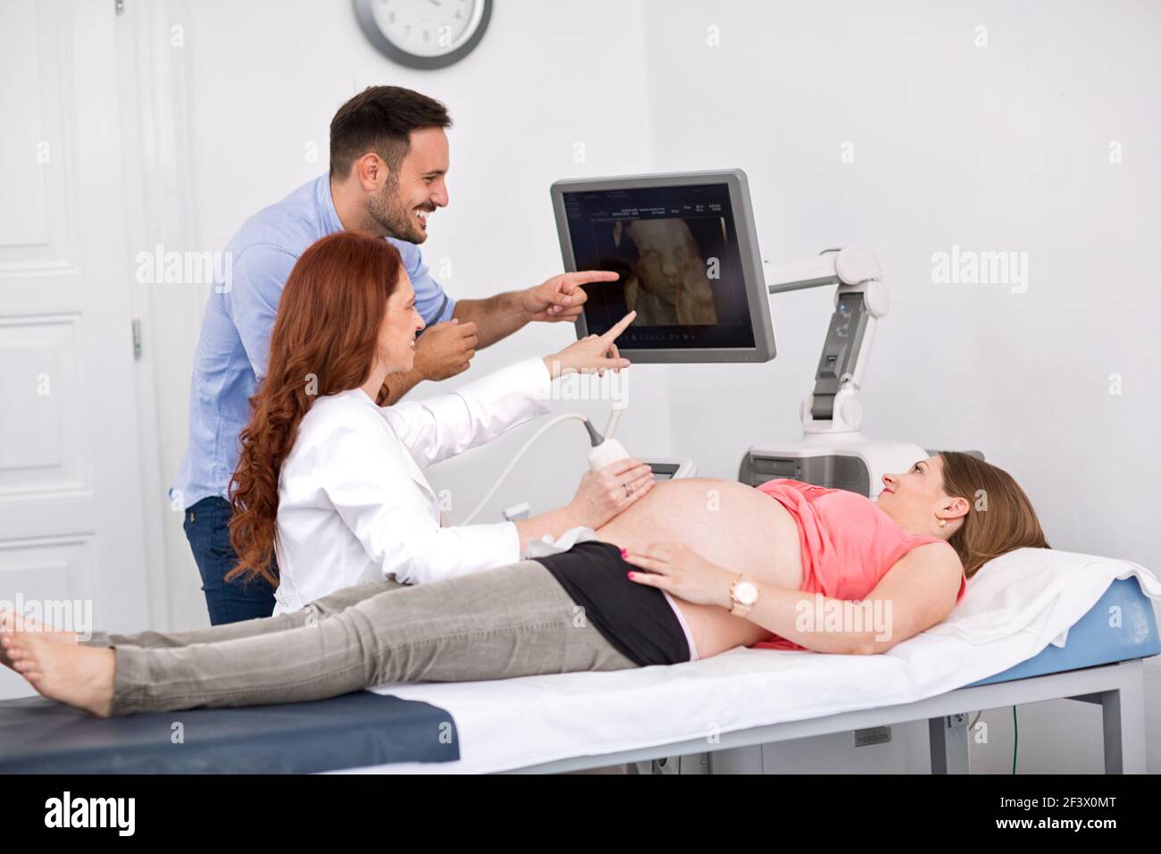 Young happy smiling couple looking at baby results of ultrasound ...